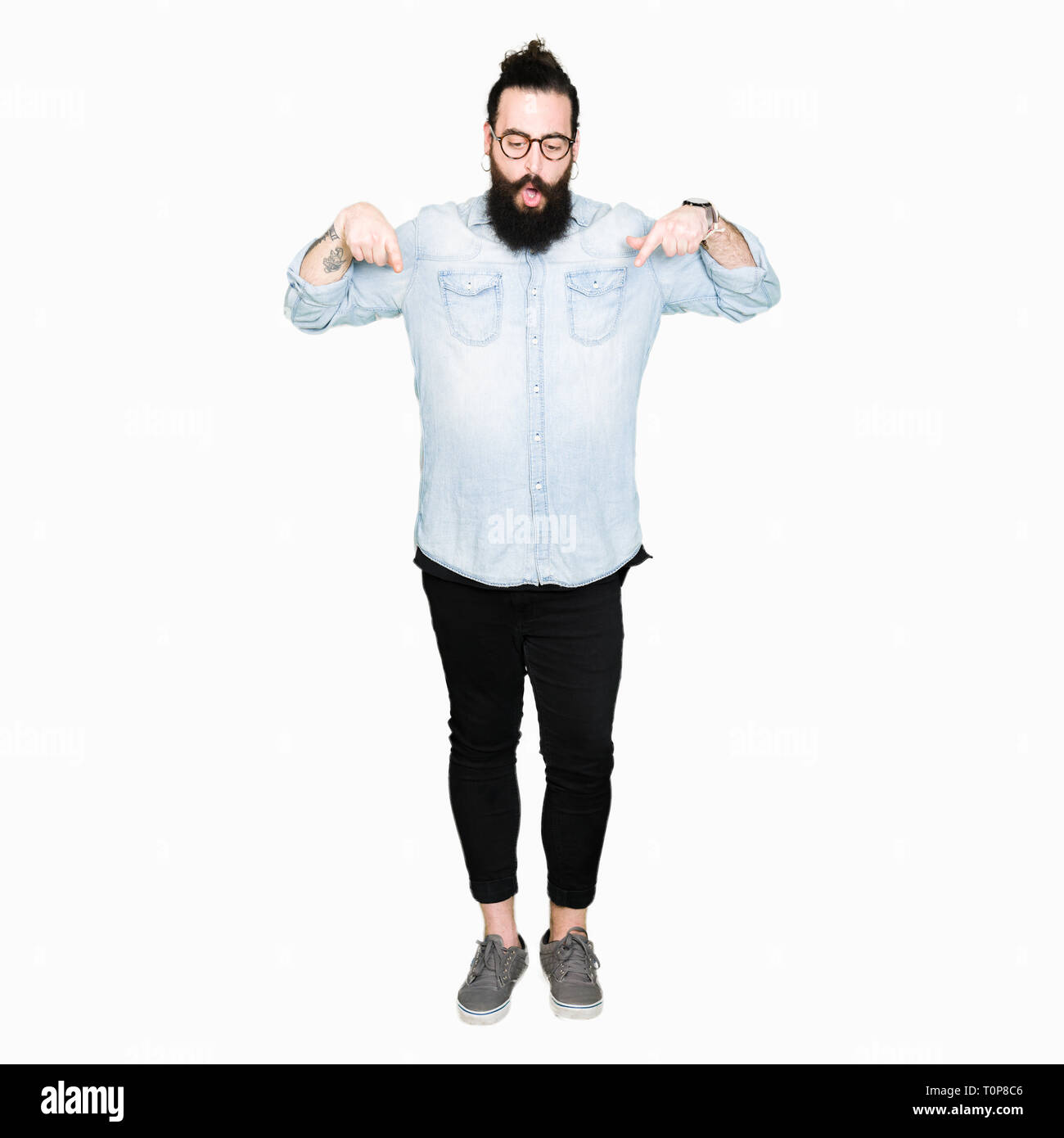 Young hipster man with long hair and beard wearing glasses Pointing ...