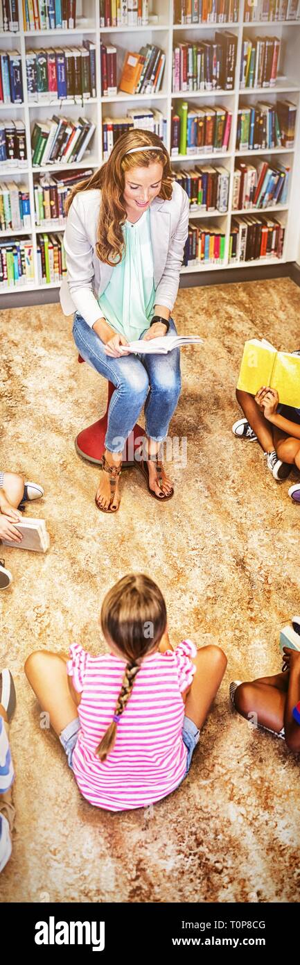 Teacher reading books to her students Stock Photo - Alamy
