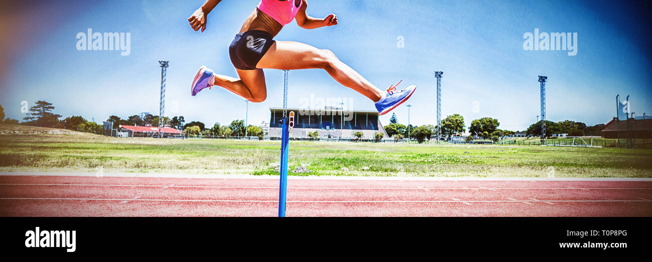 Female athlete jumping above the hurdle Stock Photo - Alamy