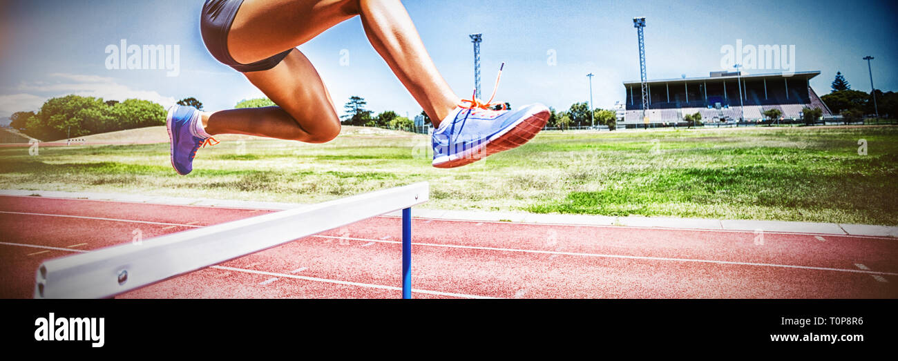 Female athlete jumping above the hurdle Stock Photo - Alamy