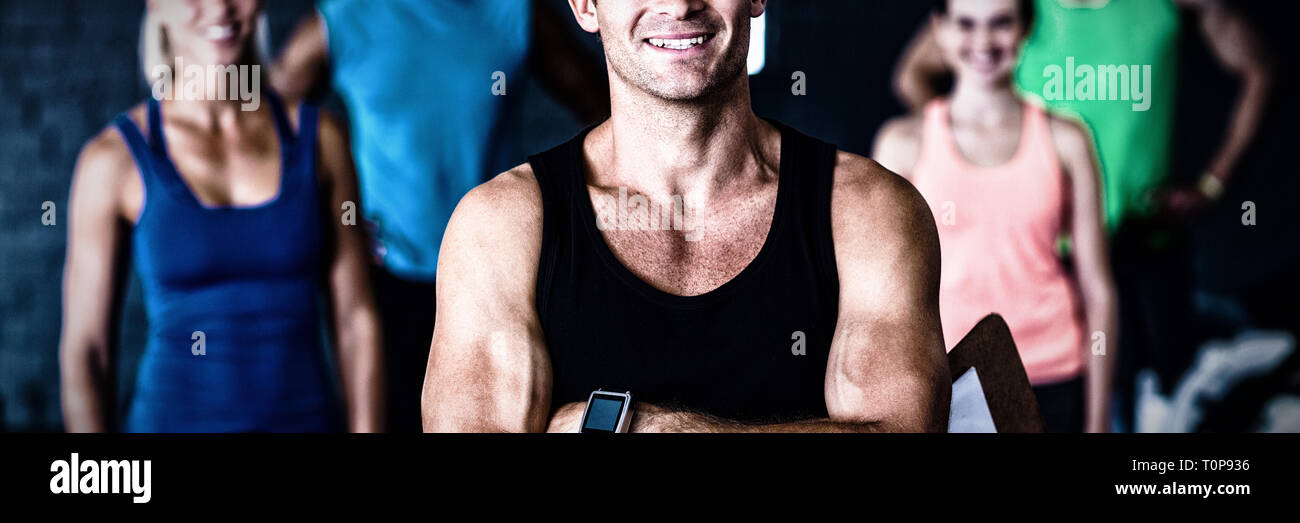 Portrait of smiling gym trainer holding clipboard Stock Photo - Alamy
