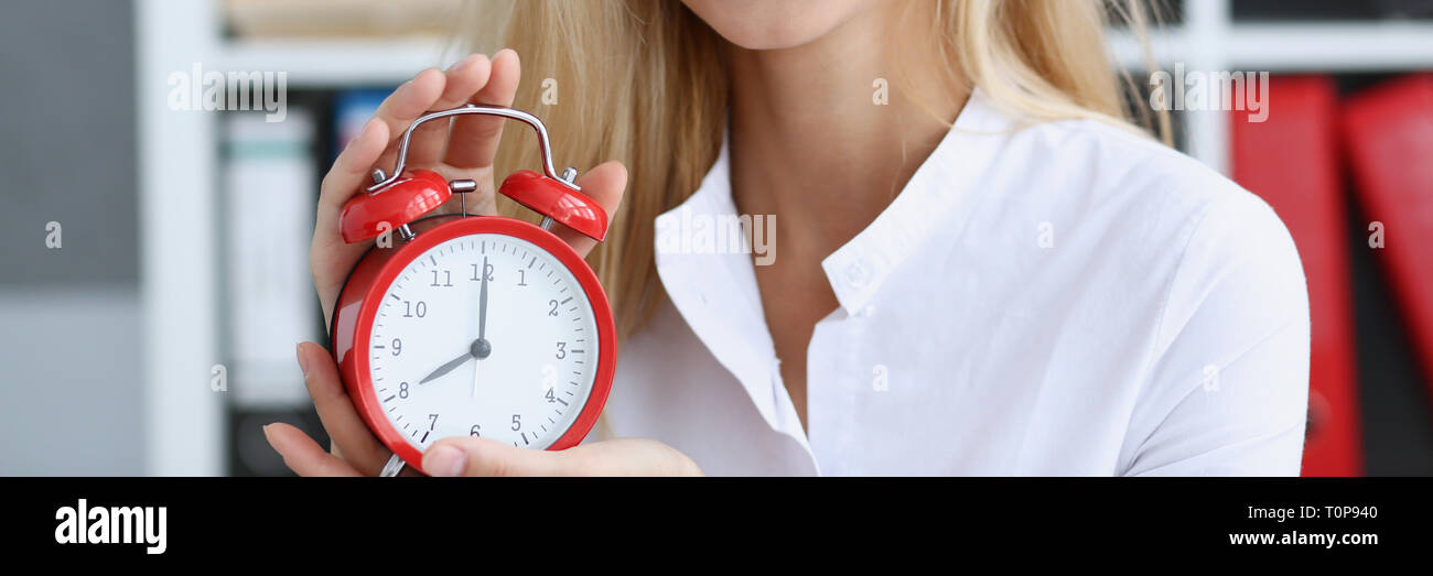 Smiling business woman holding in hand clock Stock Photo - Alamy