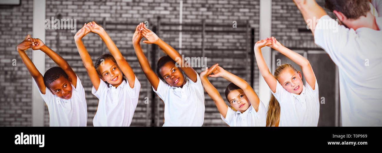 Teacher teaching exercise to school kids in basketball court Stock ...