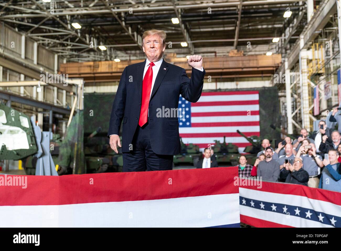 U.S President Donald Trump holds up his fist as he takes the stage to ...
