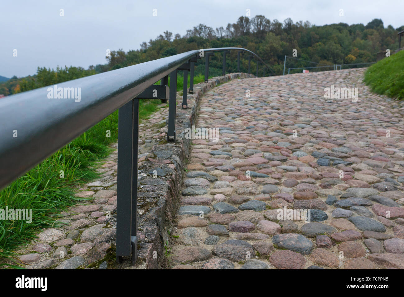 metal railings are located along the paved road Stock Photo - Alamy
