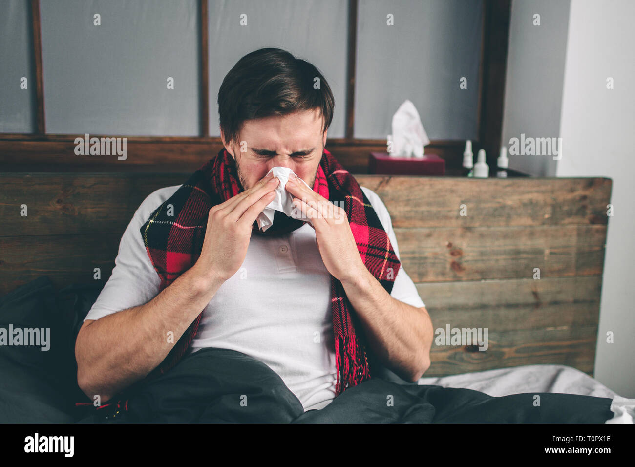 picture from a young man with handkerchief. Sick guy lies in bed and ...