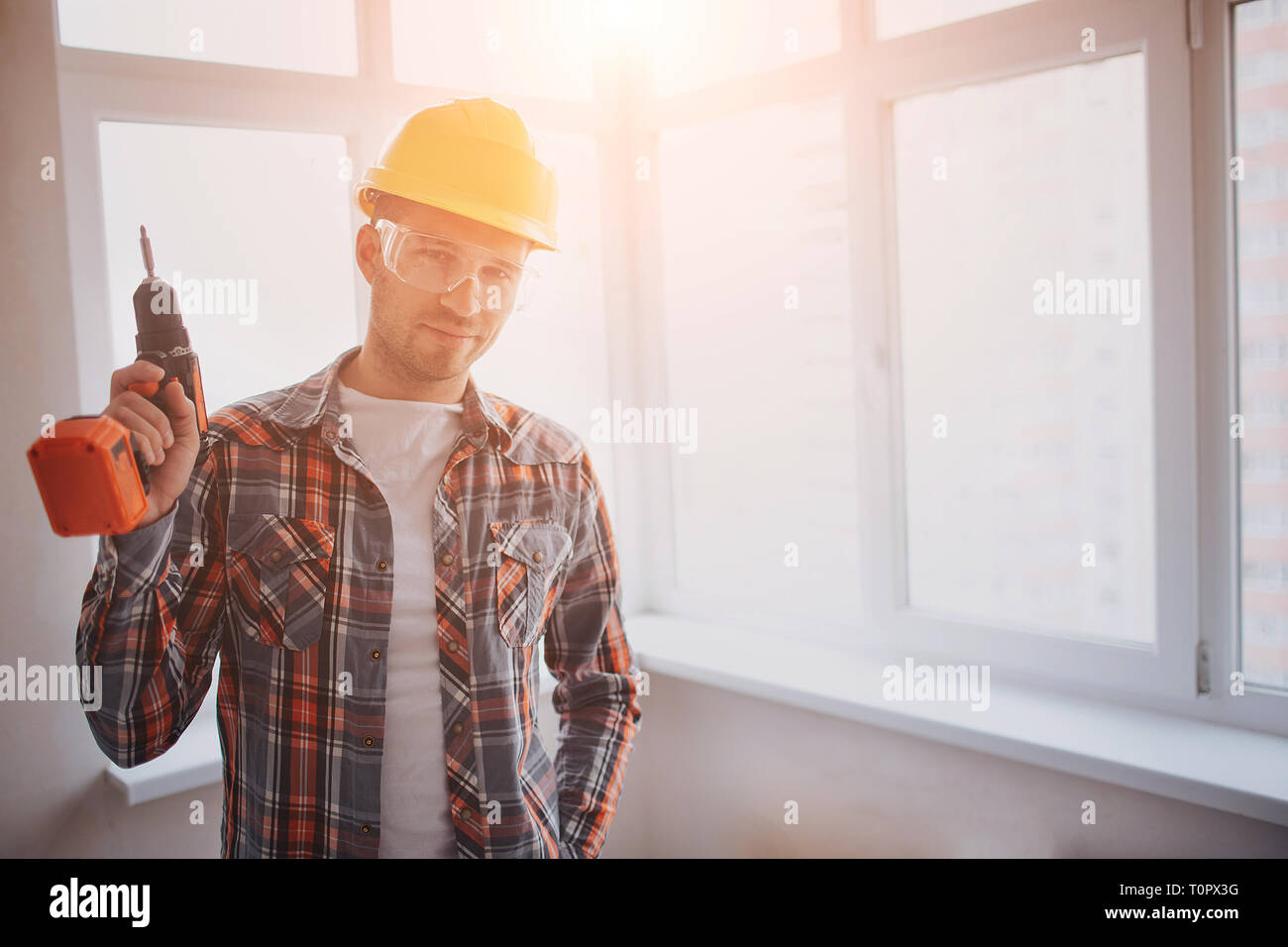 The worker or builder holds an electric drill. Building or repair ...