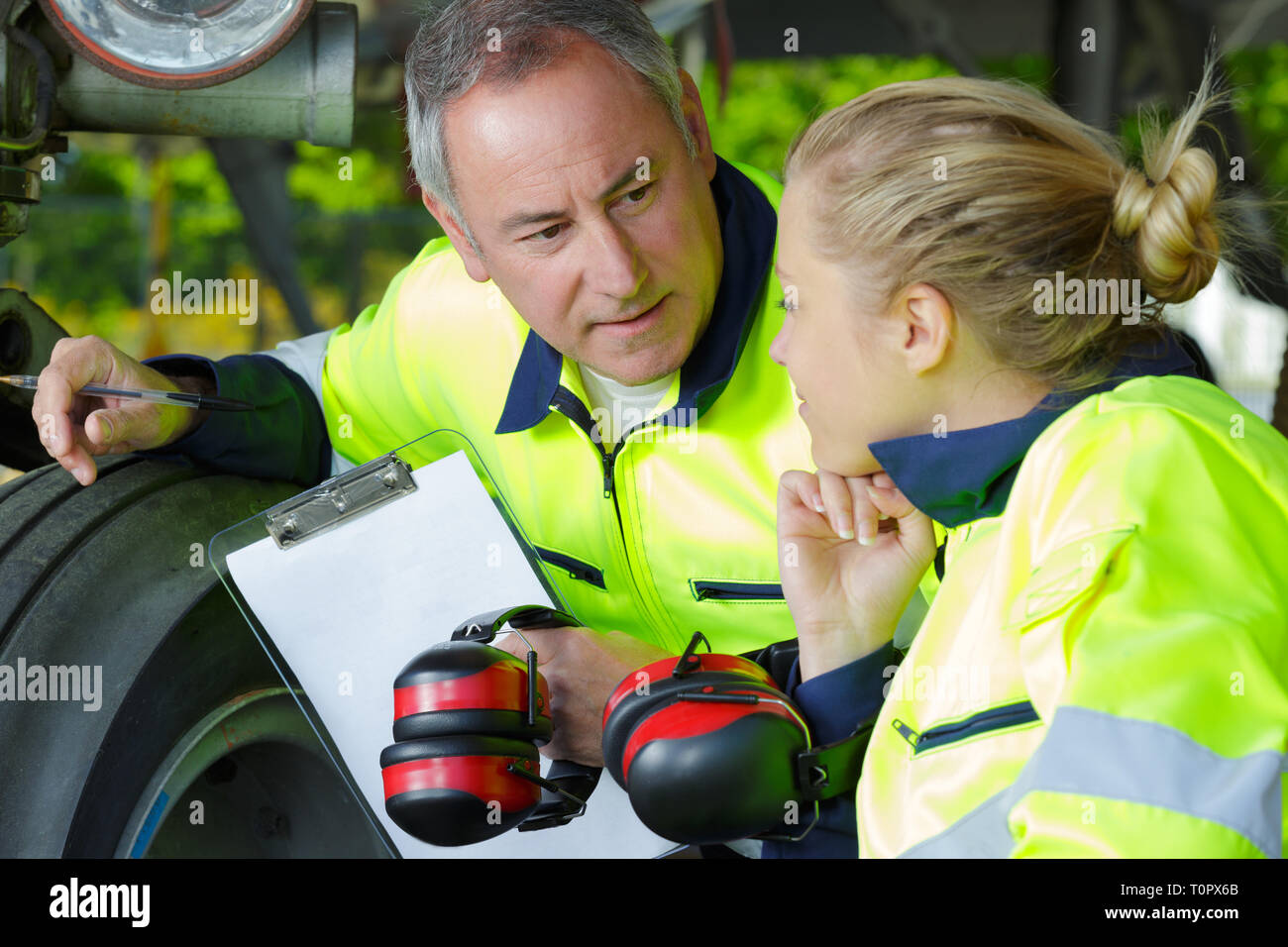 aviation mechanic with female apprentice by aircraft landing gear Stock ...