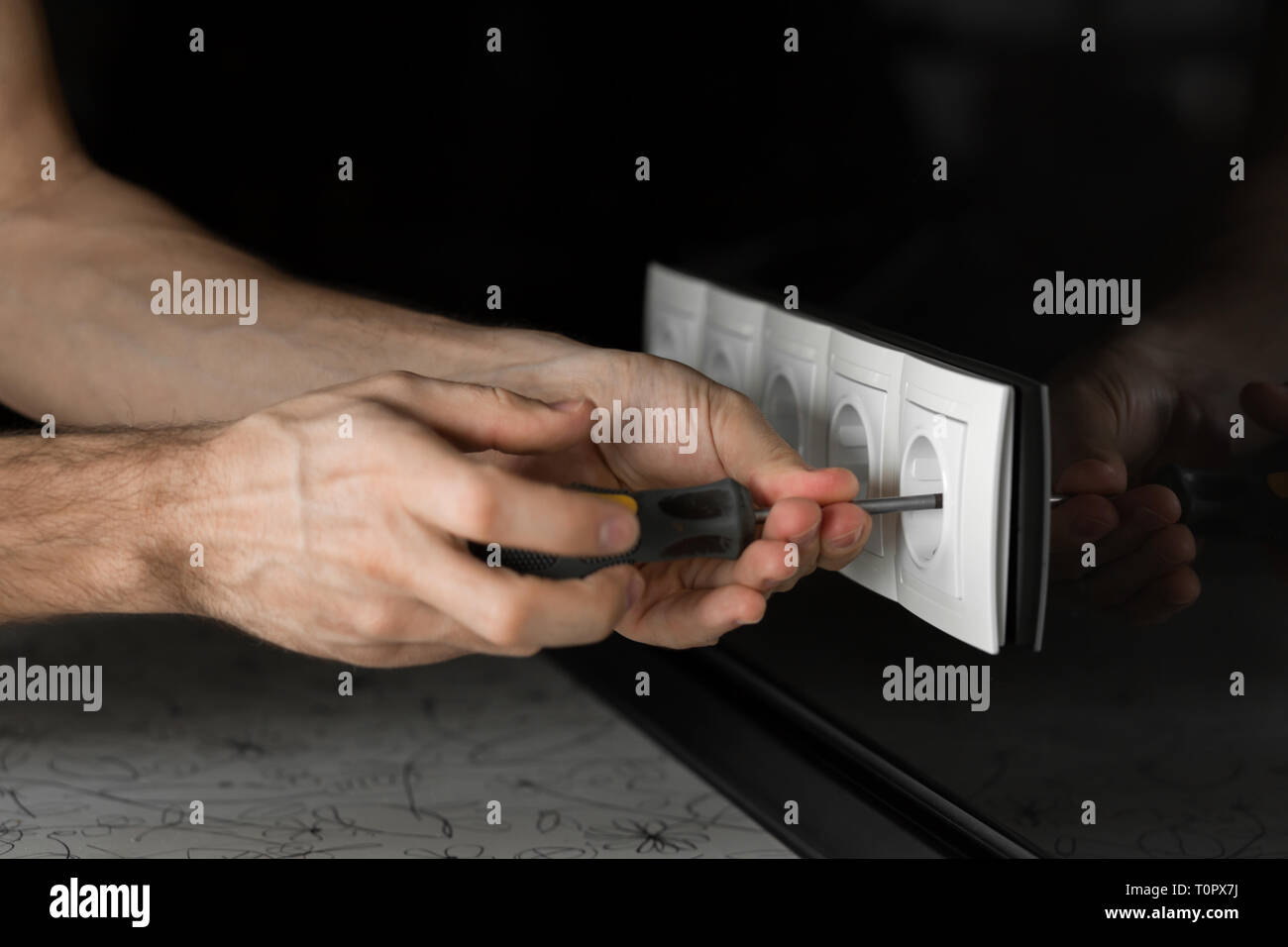 Close-up of an electrician's hand with a screwdriver disassembling a ...