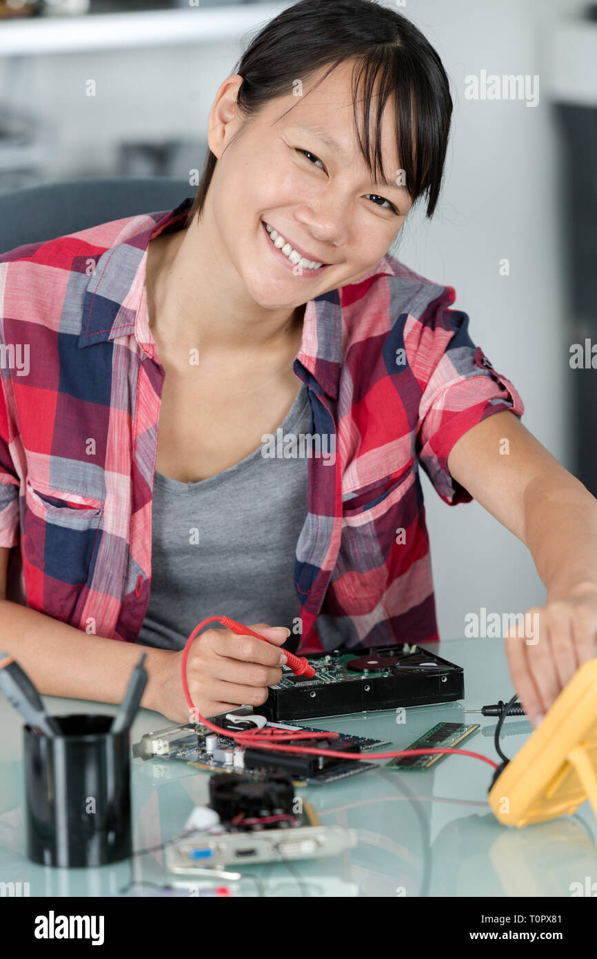 female asian computer technician using multimeter Stock Photo - Alamy