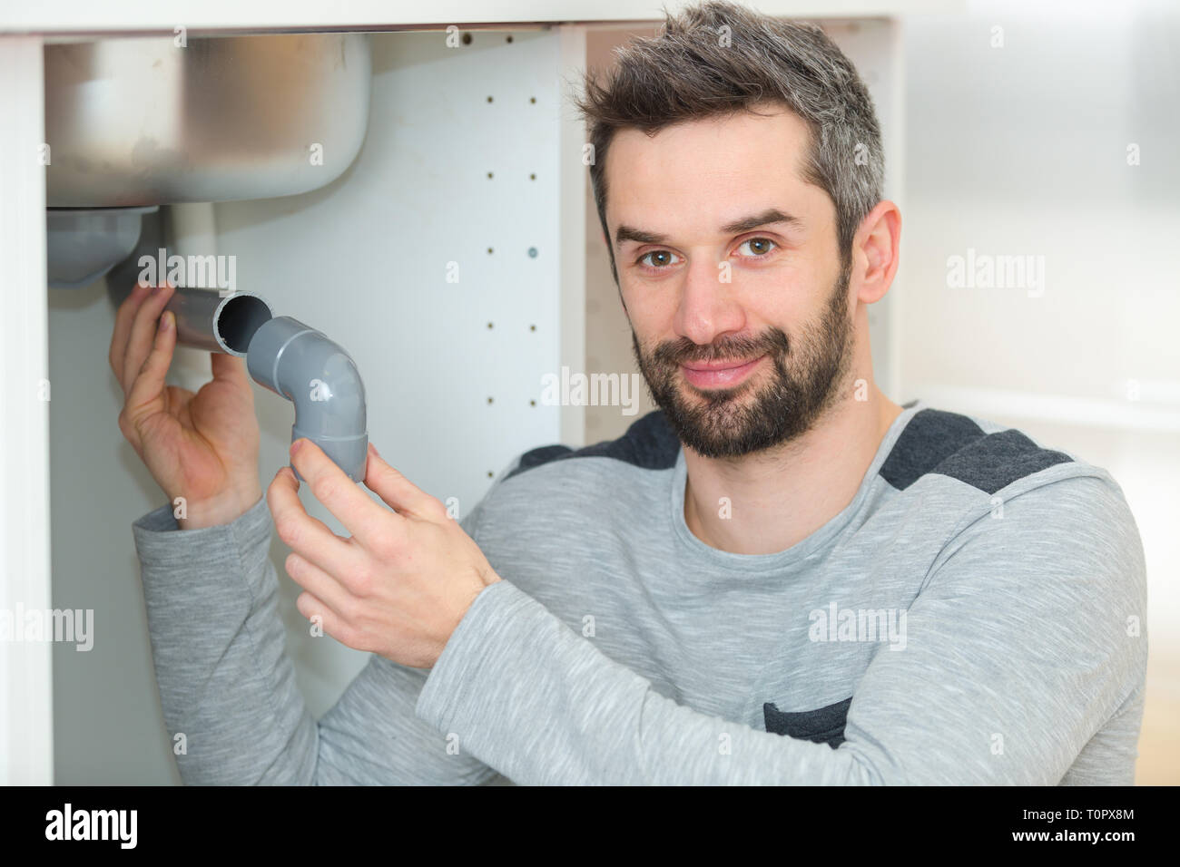 Handsome plumber repairing drain sink hi-res stock photography and ...