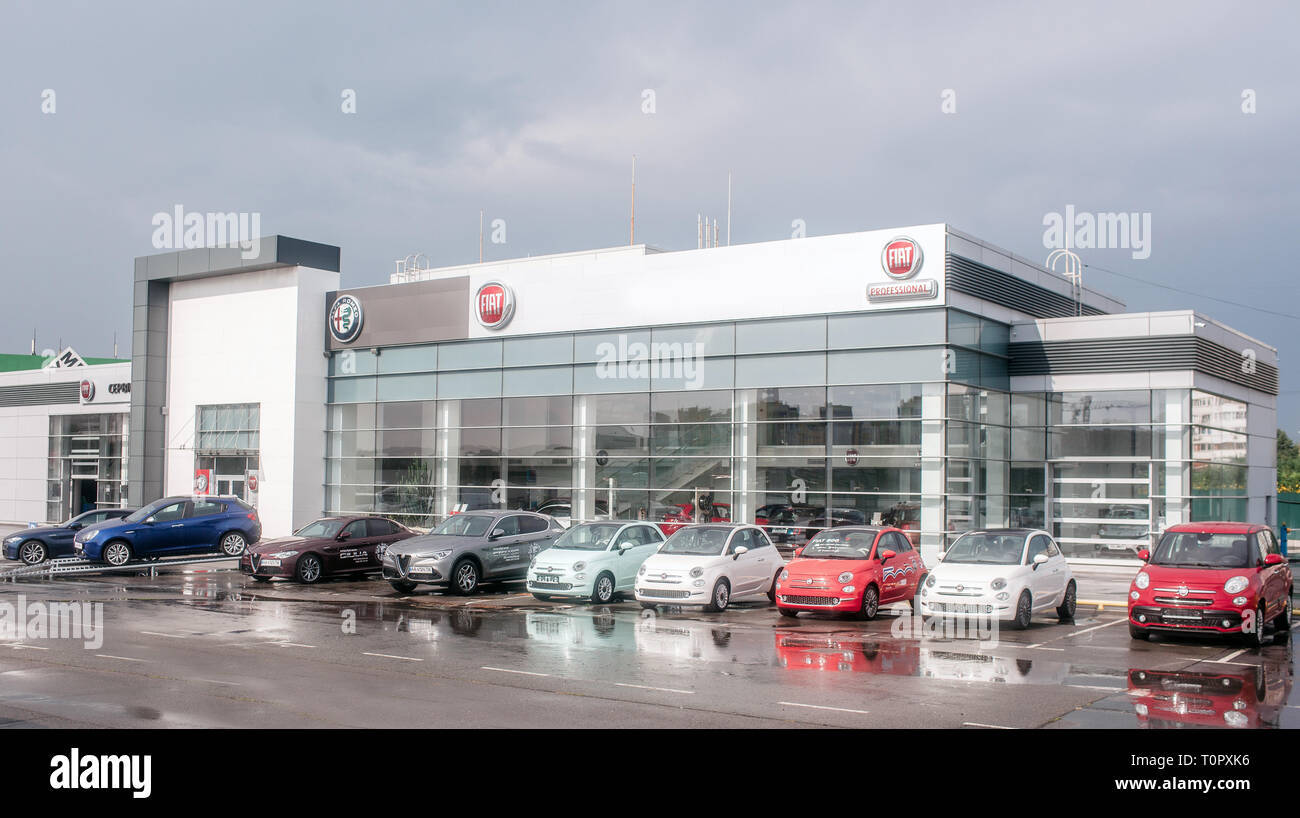Picture of Fiat dealer salon with cars outside of it. There are cars ...