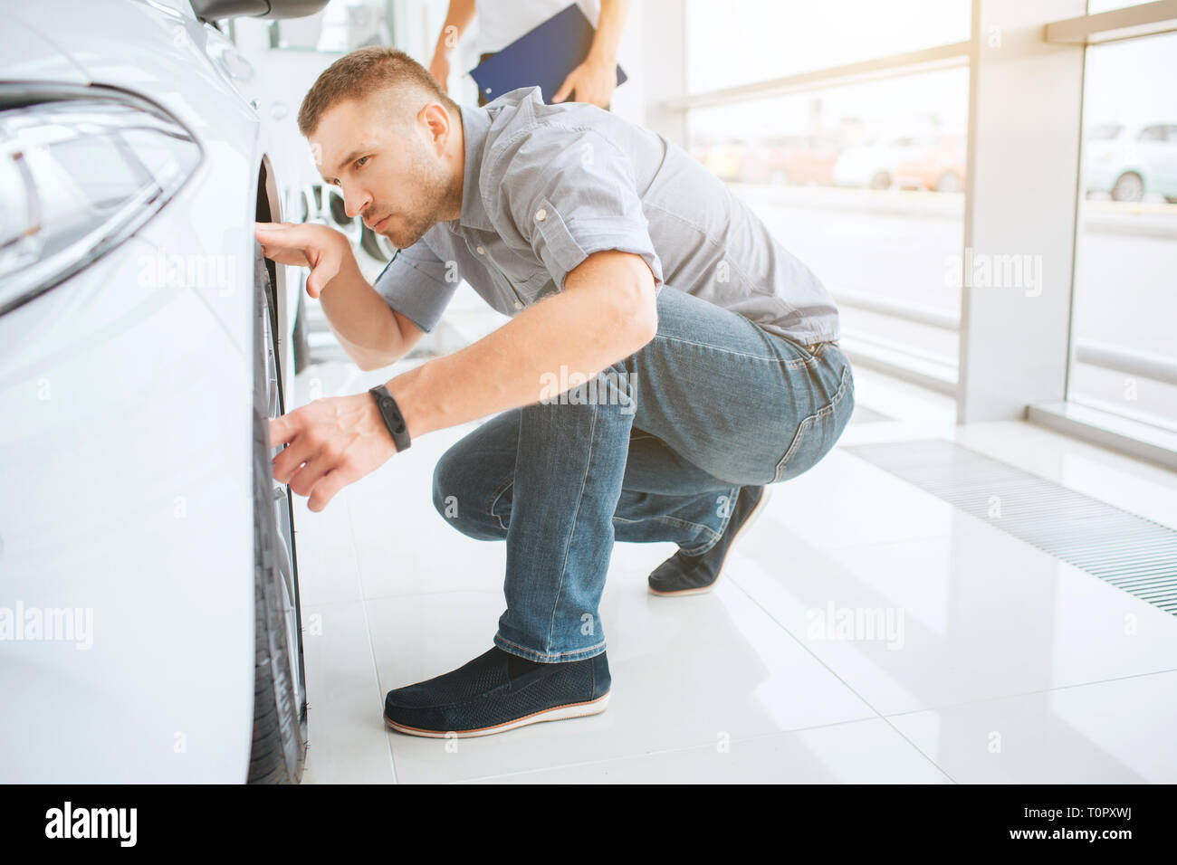 Picture of young man sitting in squad position and look at space ...