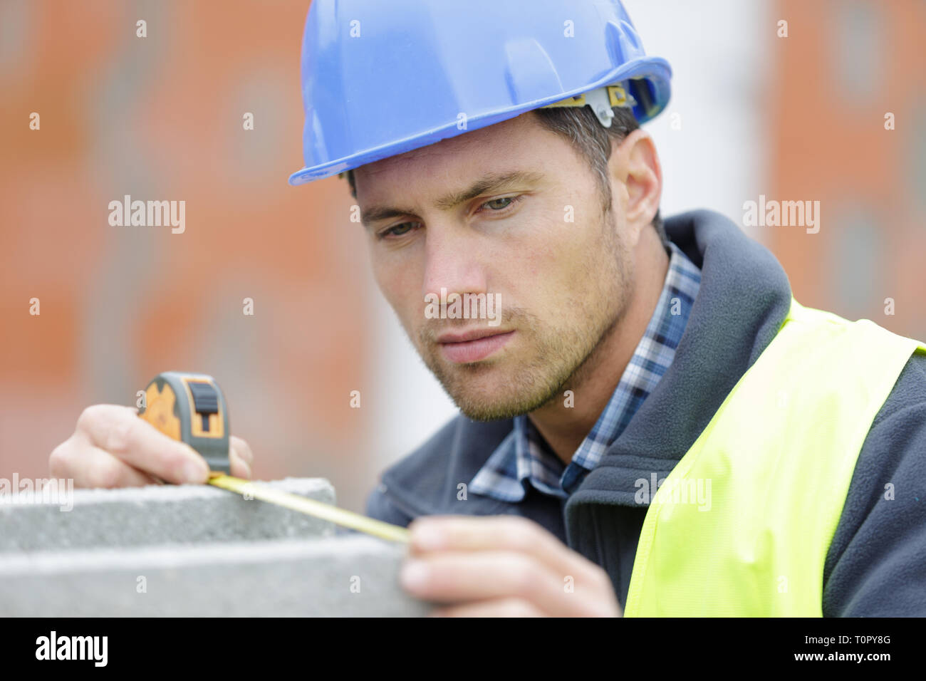 construction worker is measuring a cement block Stock Photo - Alamy