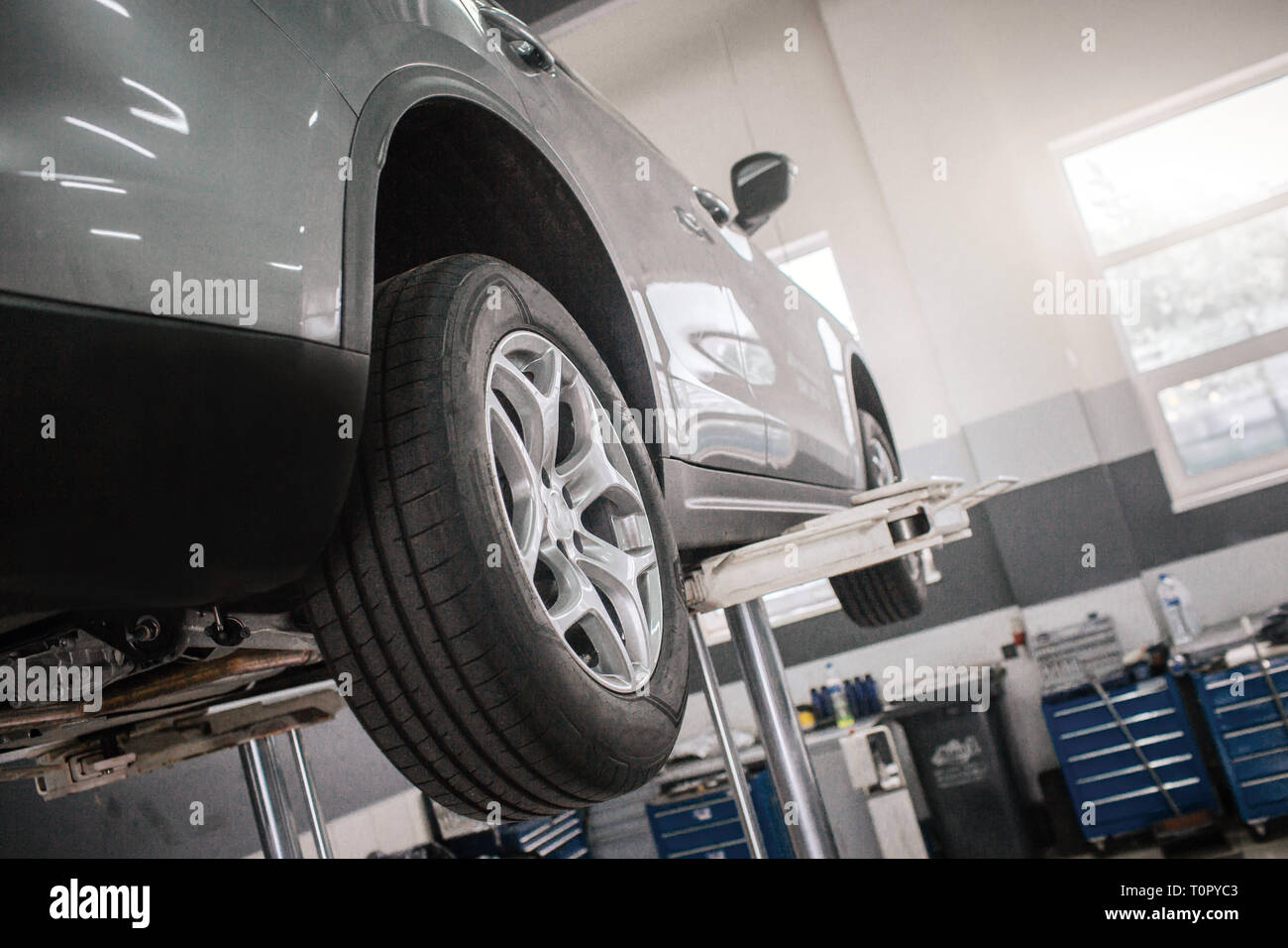 Cut view of grey car standon platform. It is shown low part of car ...