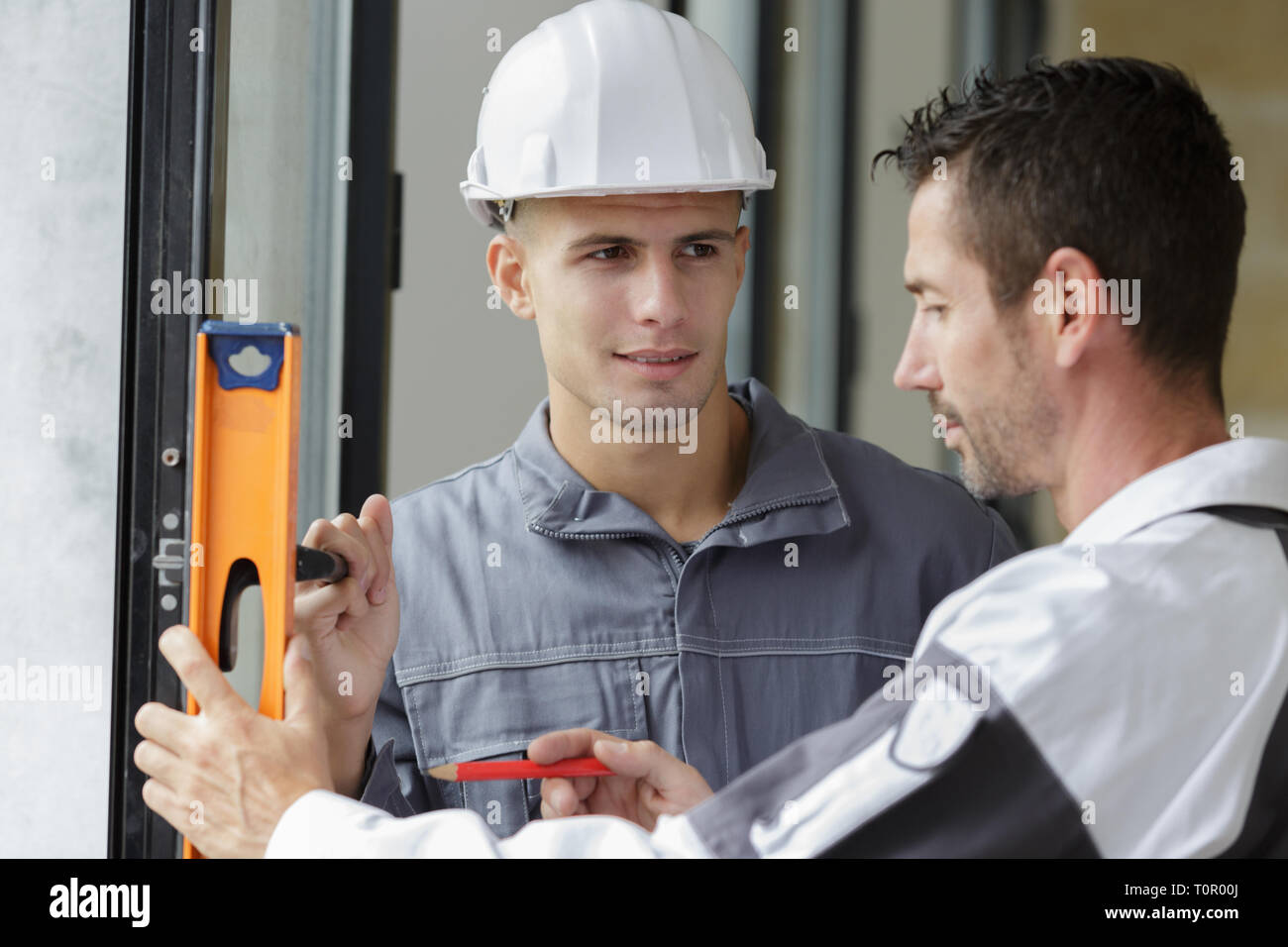 window fitting team using spirit level Stock Photo - Alamy