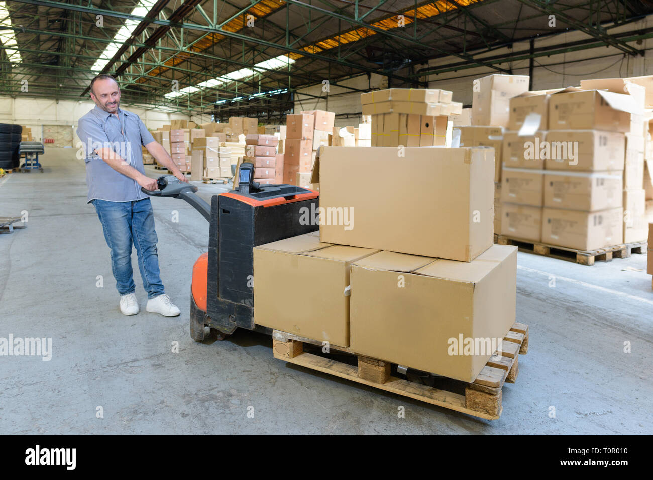 porter carrying boxes in a warehouse Stock Photo - Alamy