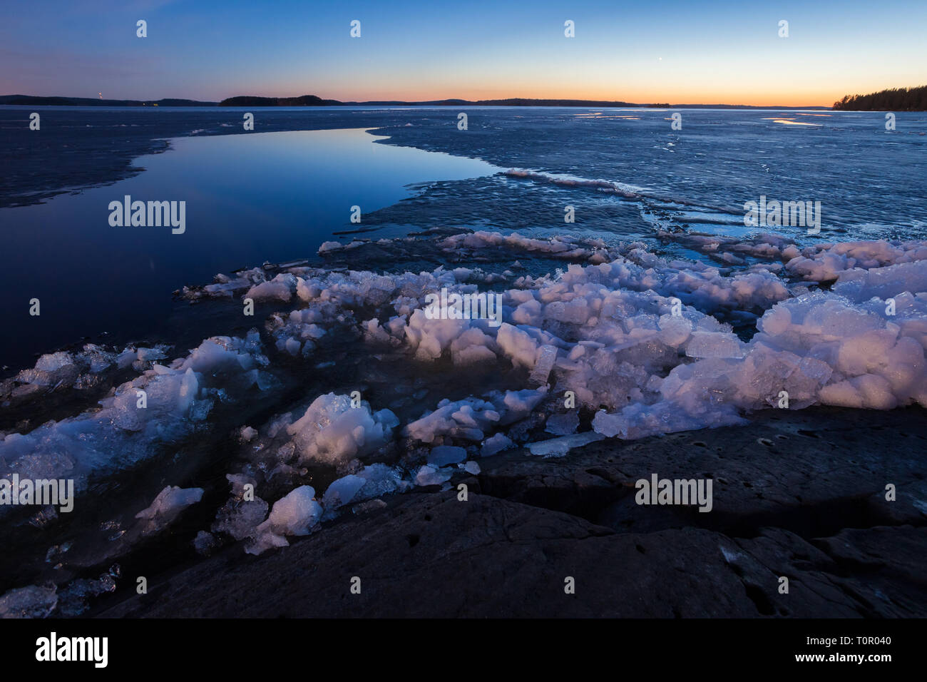 Partially melting ice in lake at night Stock Photo - Alamy