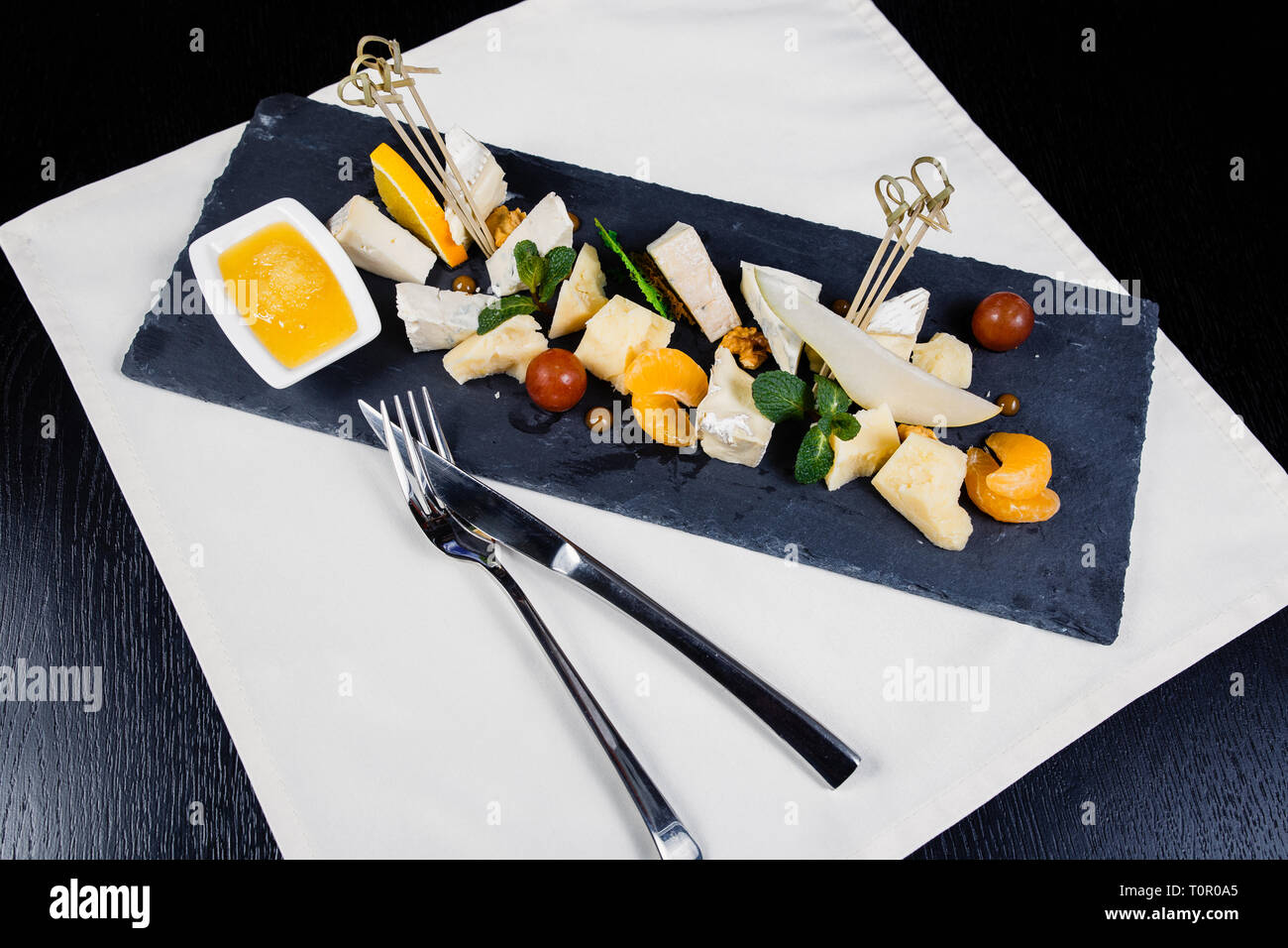 Cheese plate Assortment of various types of cheese on dark slate ...