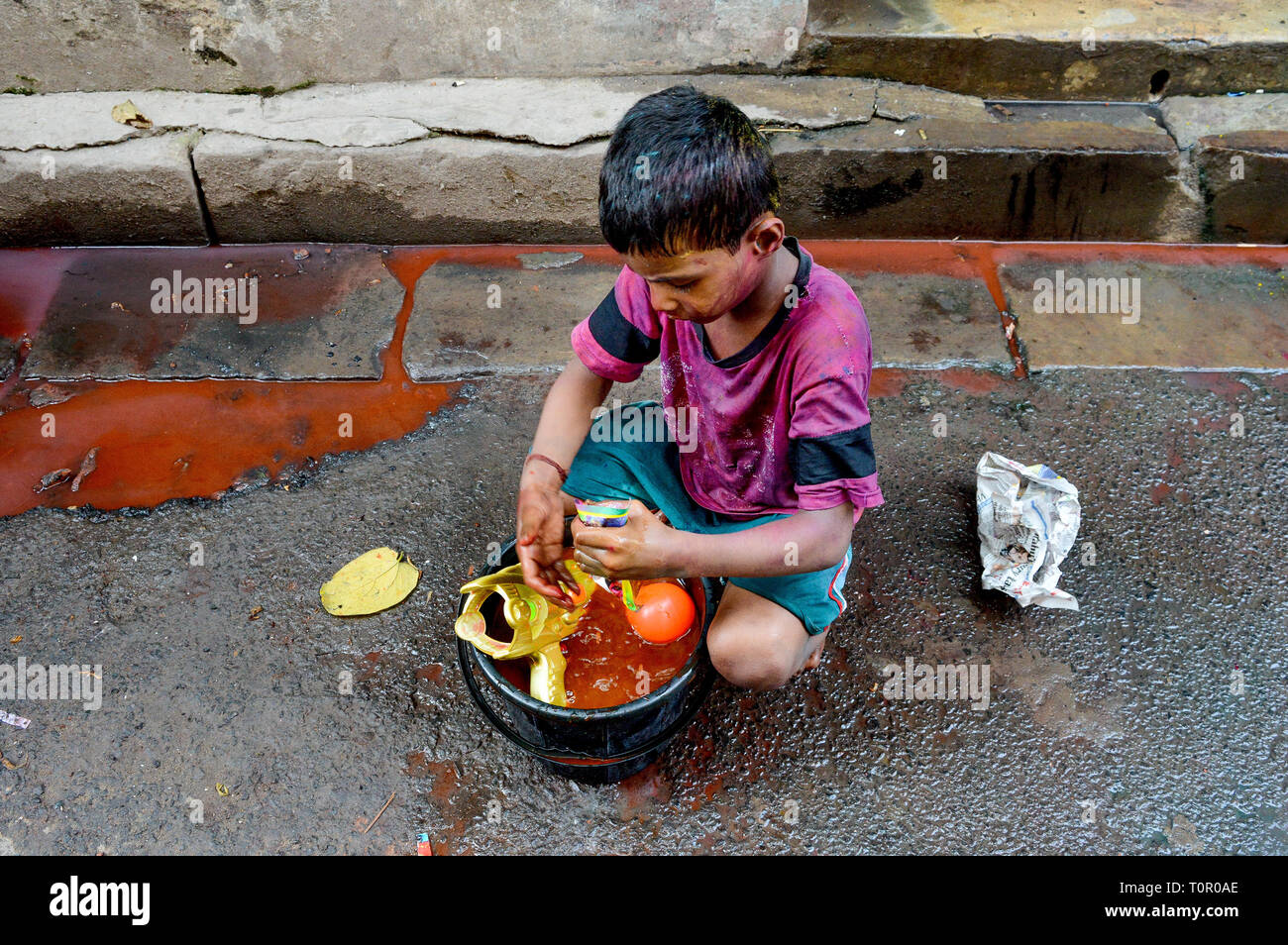 Kolkata, India. 21st Mar, 2019. A boy filling up her water pistol with ...