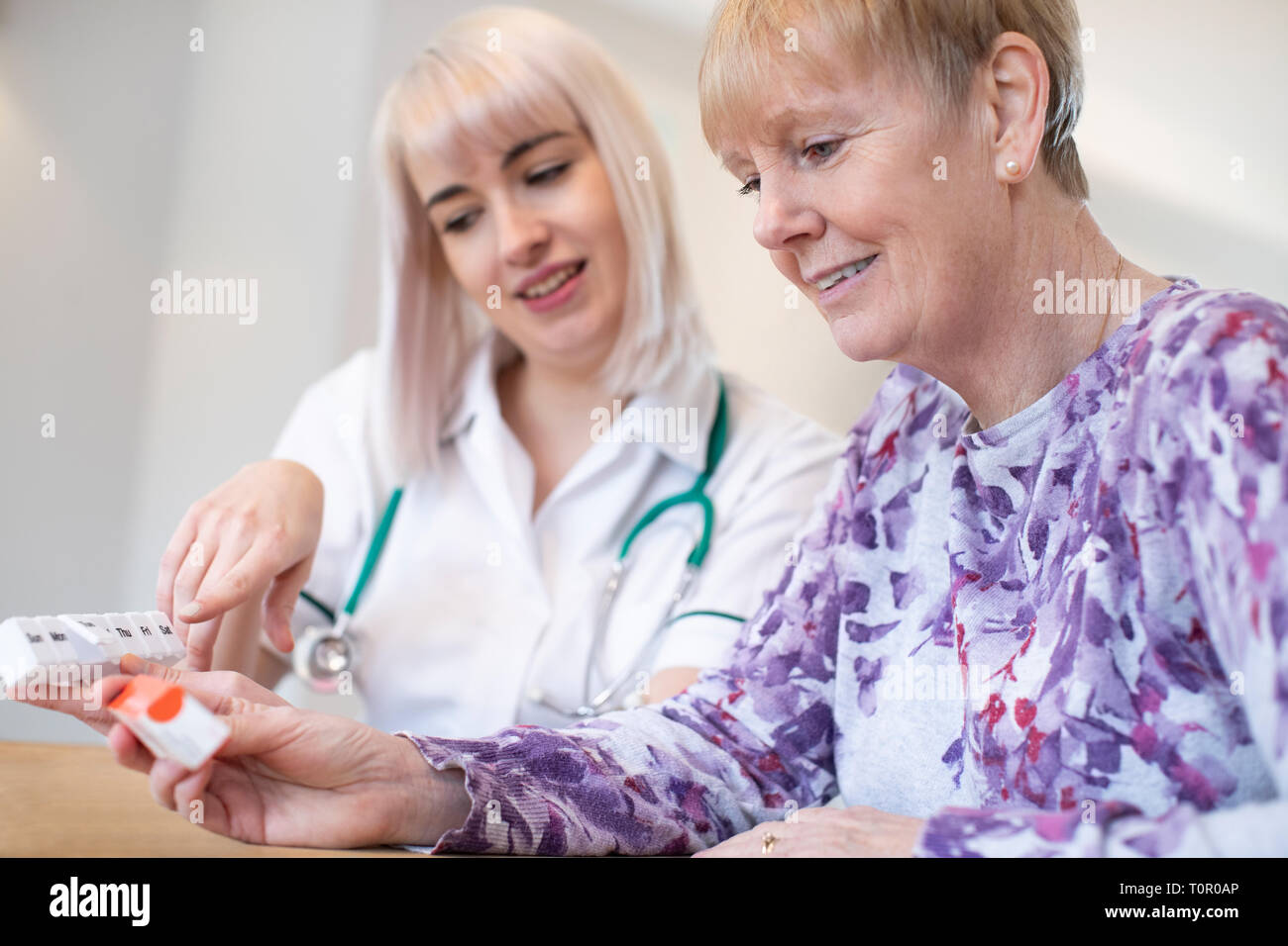 Female Nurse Discussing Medication With Senior Woman Patient Stock ...