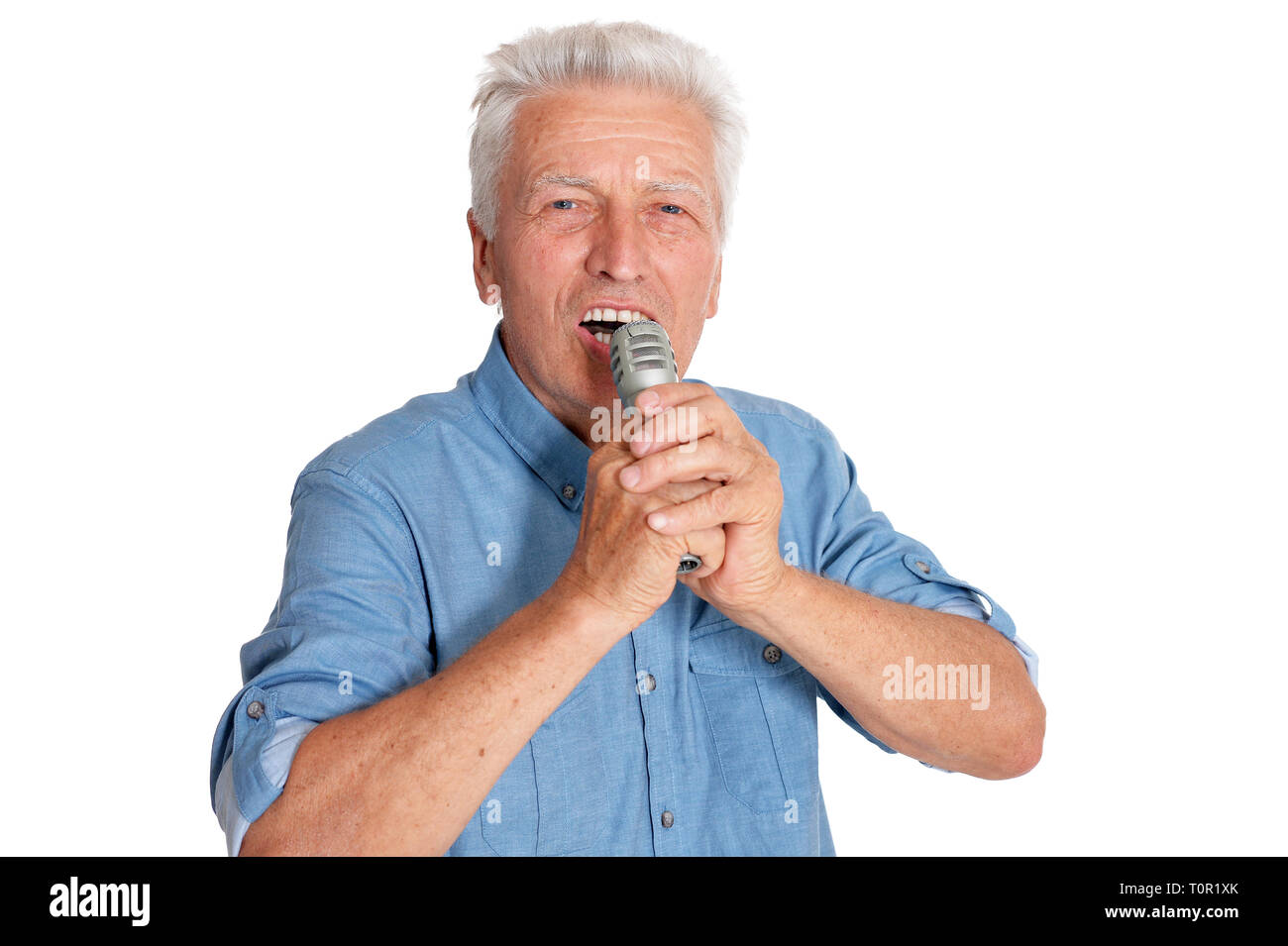 Senior man singing into microphone on white background Stock Photo - Alamy