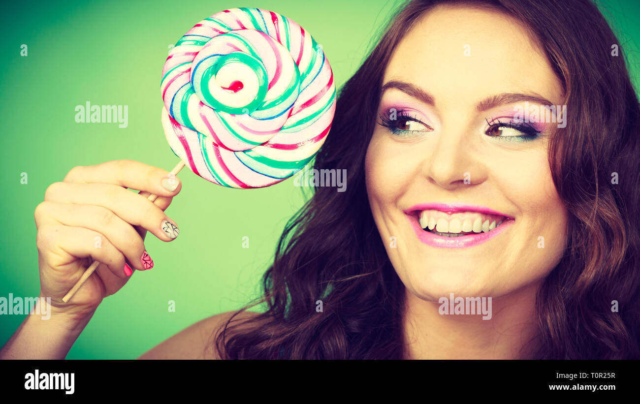 Woman beautiful cheerful girl holding colorful lollipop candy in hand ...
