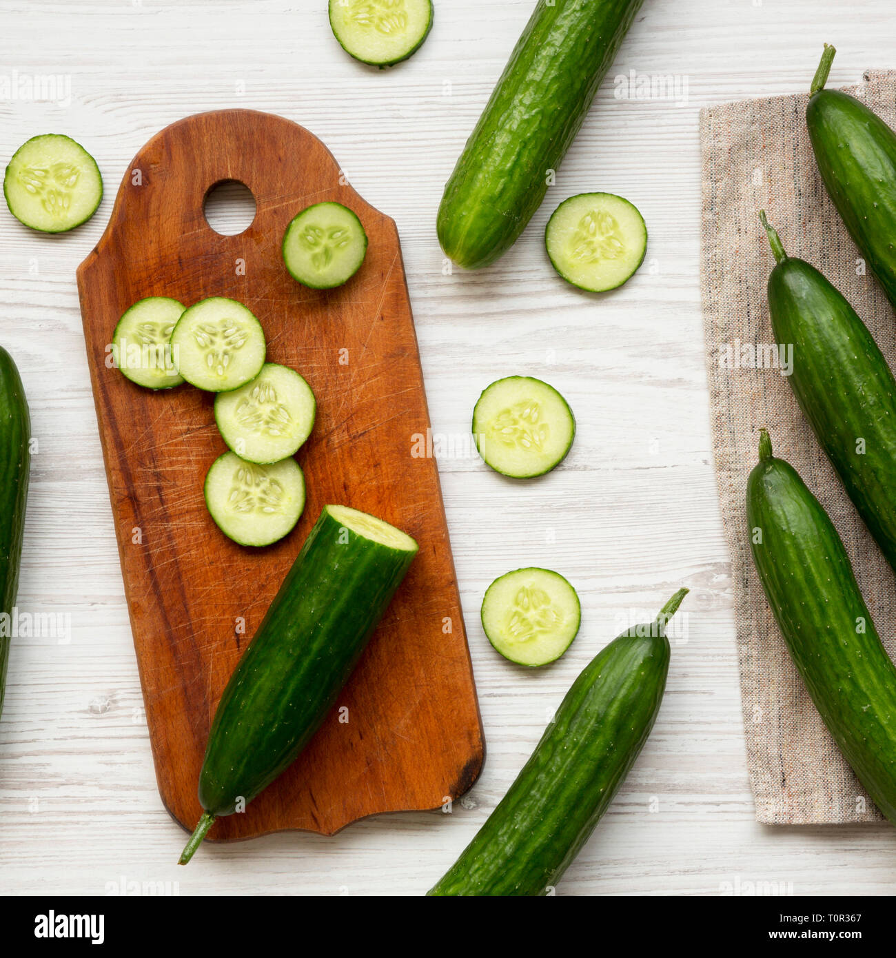 Top view, fresh raw green cucumbers over white wooden background. Flat ...