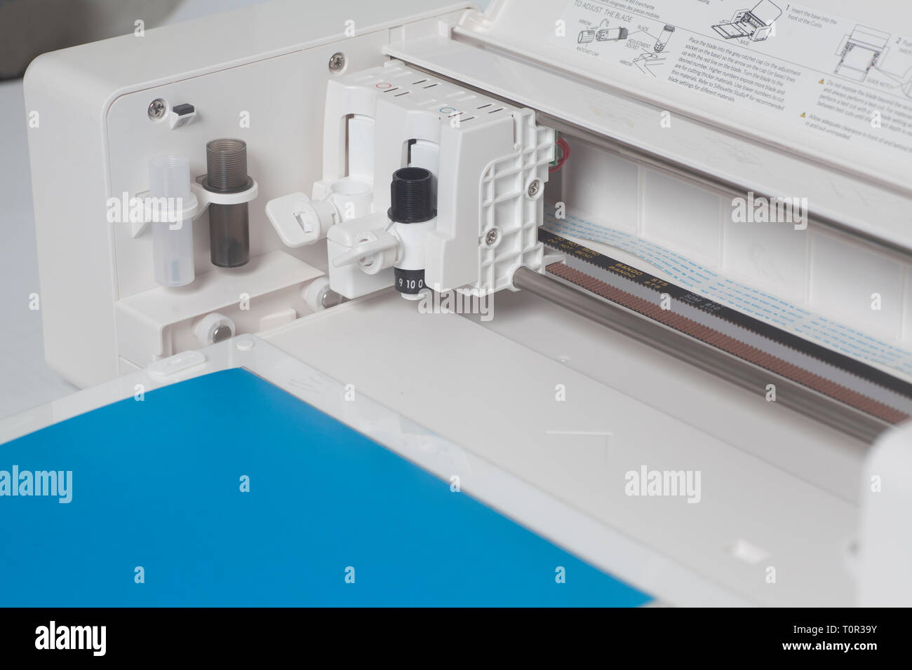 Cutting plotter with blue paper close up Stock Photo - Alamy