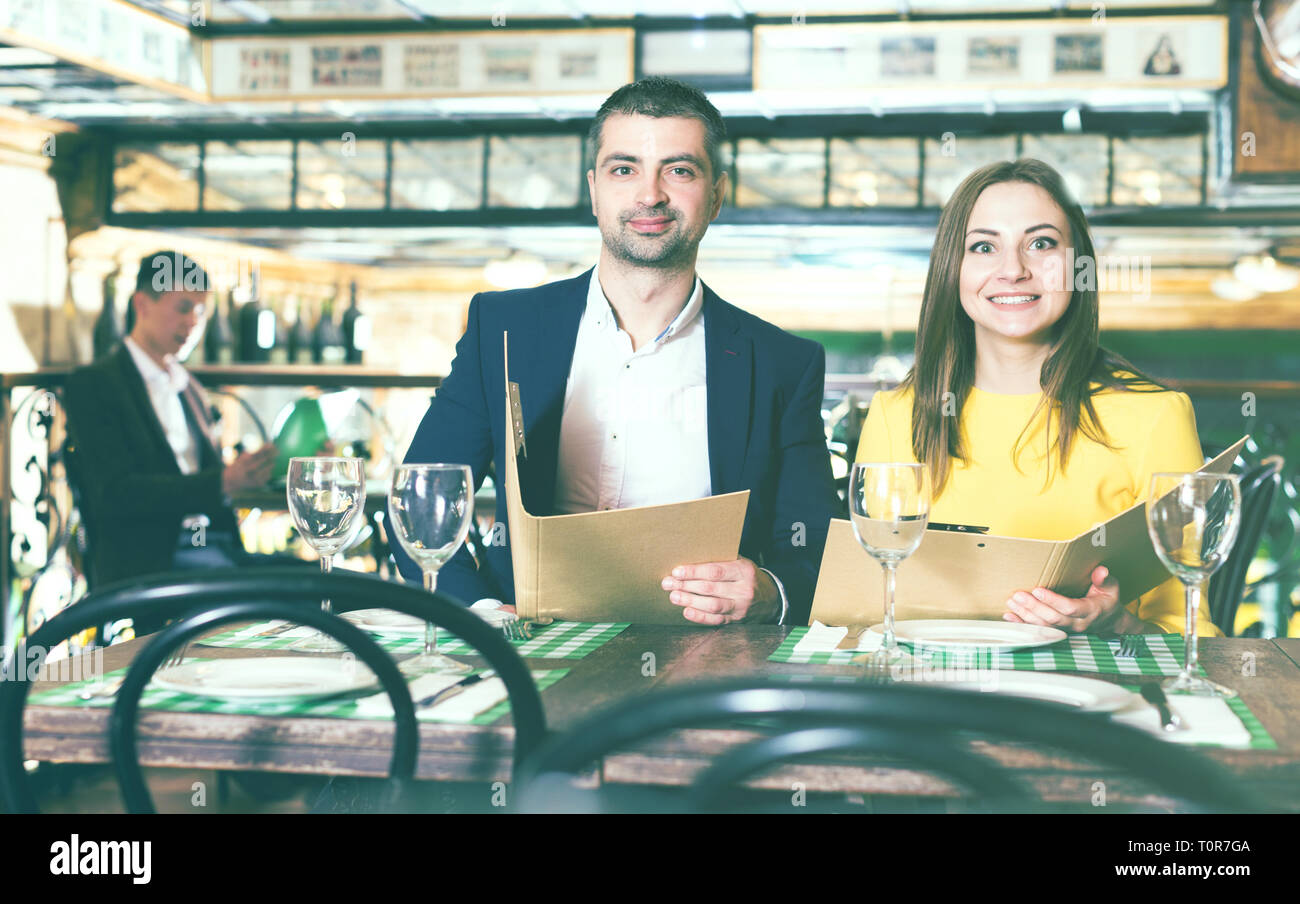 Couple with menu is choosing order in time dinner in restaurant Stock ...