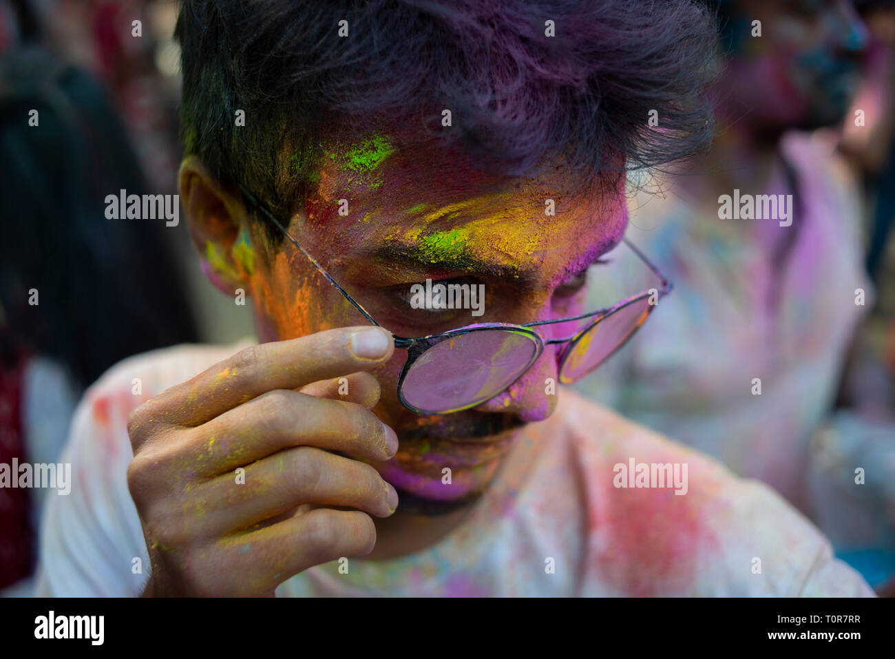 A man seen with colours all over her face during the Holi festival ...