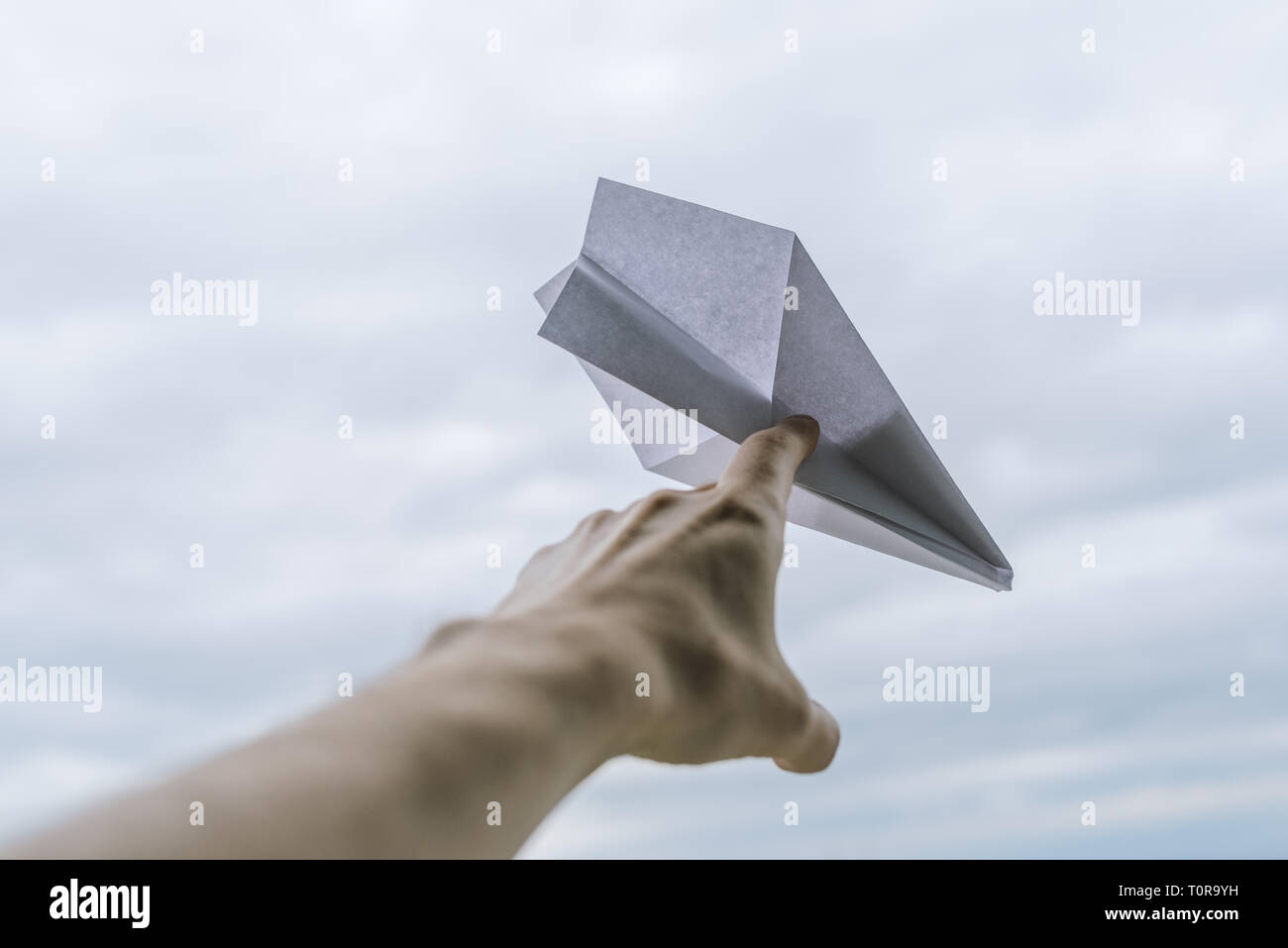 Paper plane in hand on sky background Stock Photo - Alamy