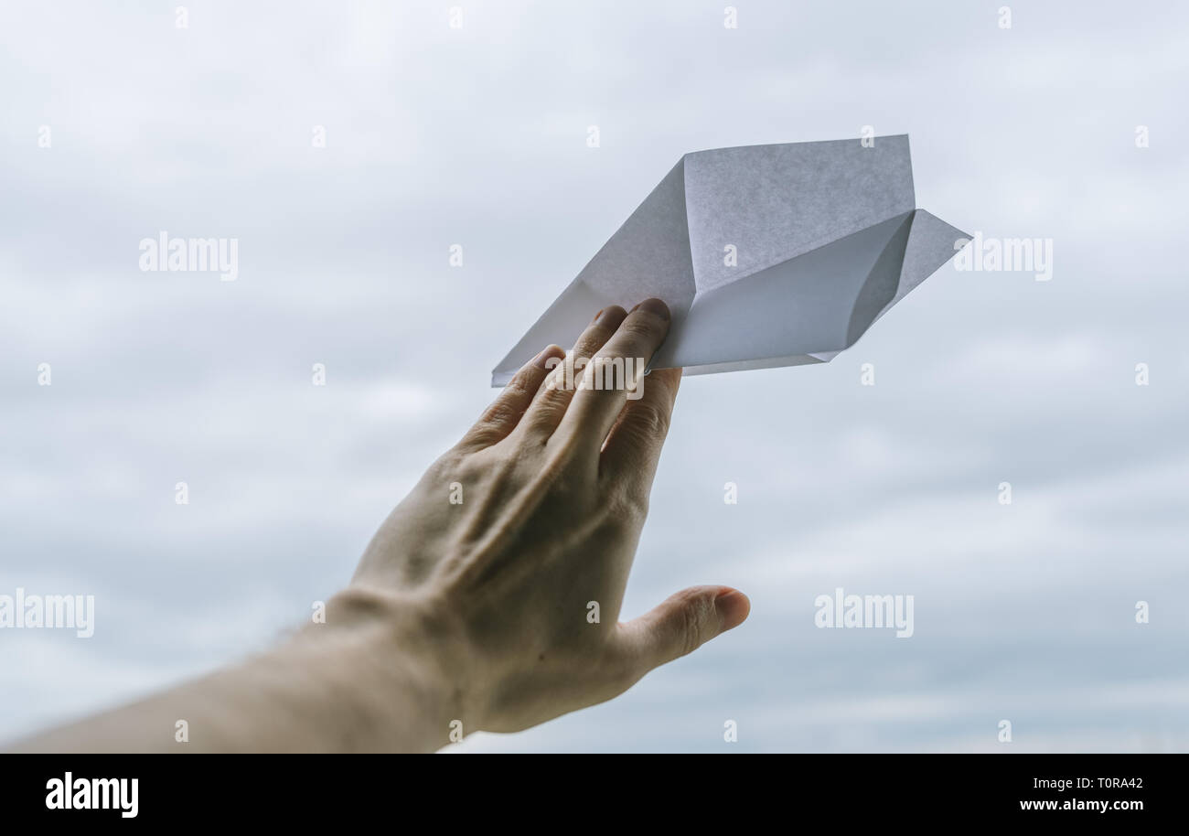 Paper plane in hand on sky background Stock Photo - Alamy