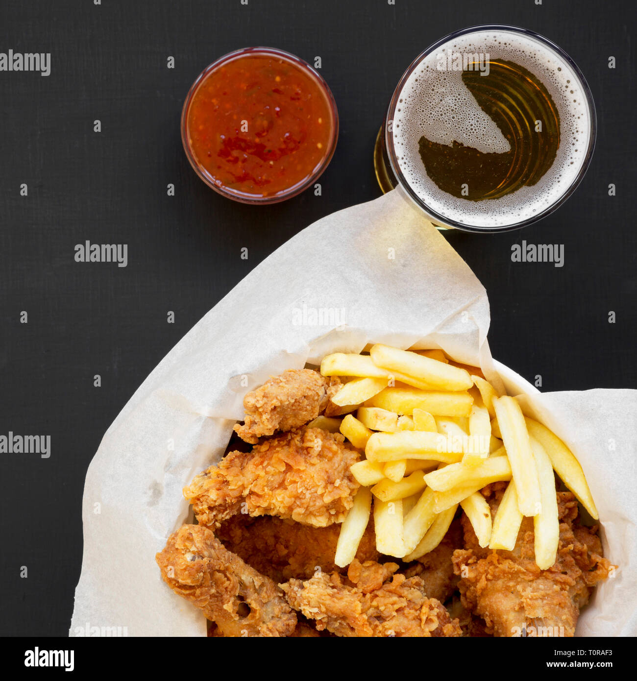 Tasty fastfood: fried chicken legs, spicy wings, French fries and ...