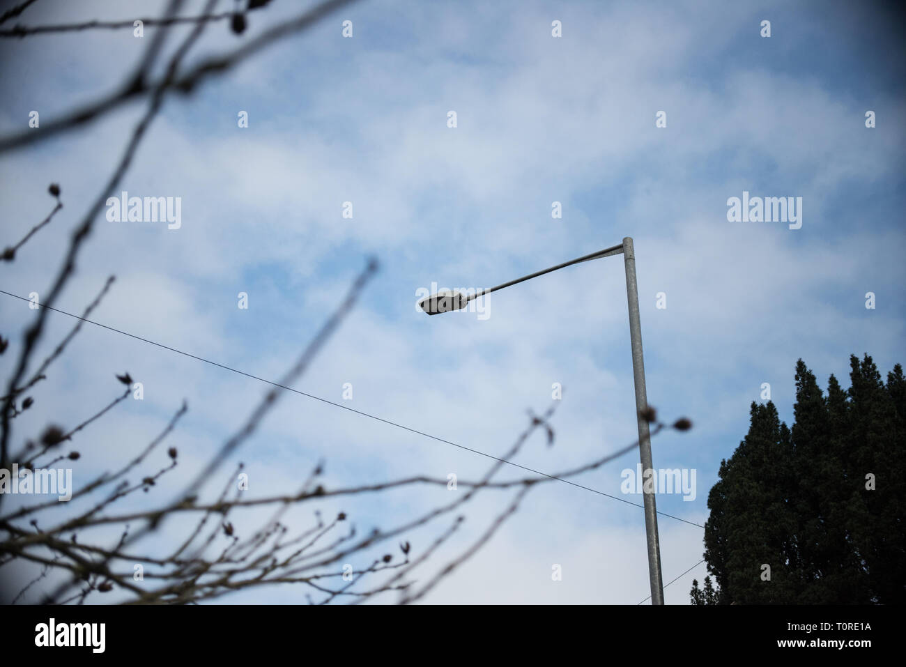 Lamp-post / street-light with cables behind it against a Blue sky and ...