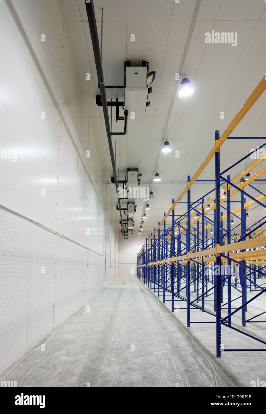Large newly build warehouse with steel shelves and freezing equipment ...