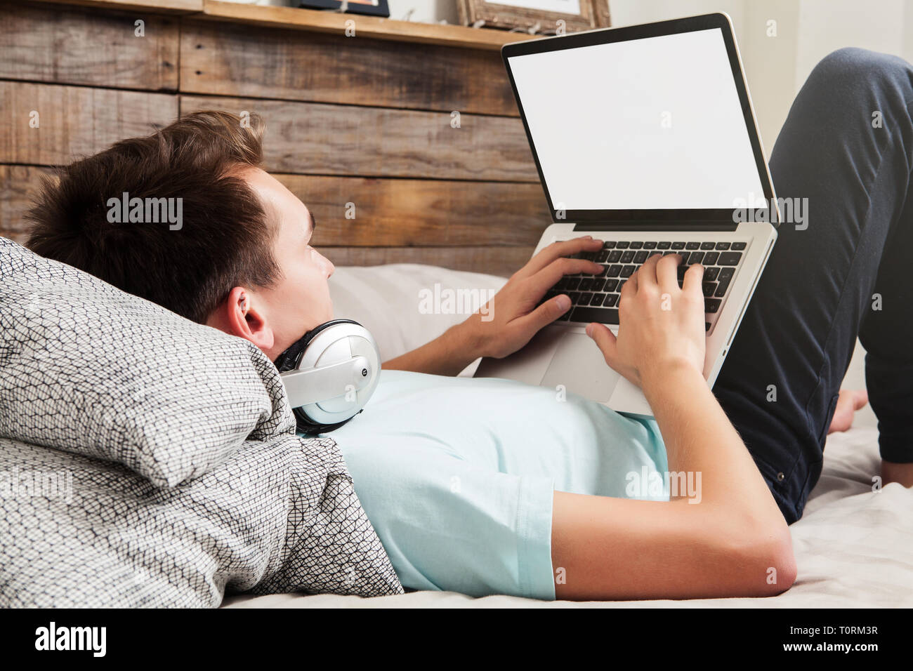 Man using a laptop computer with white blank screen while resting on ...