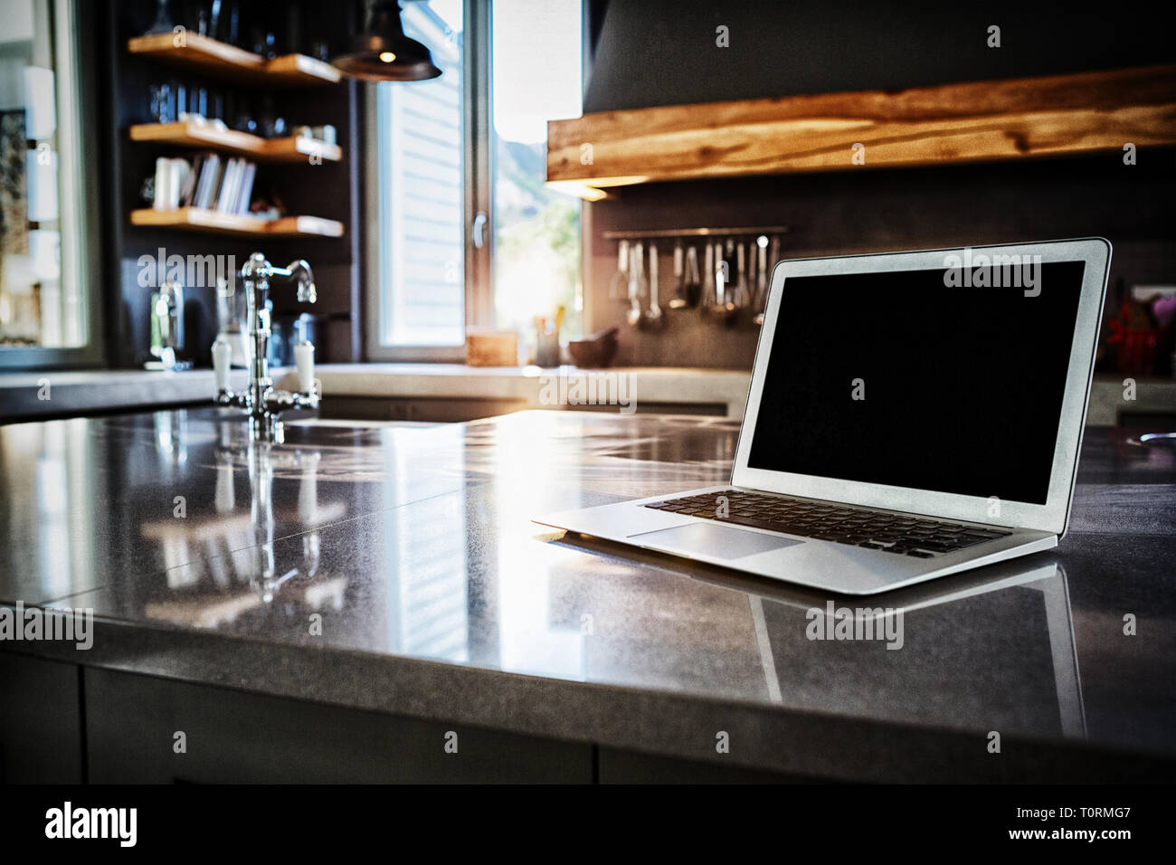Laptop on kitchen counter Stock Photo - Alamy