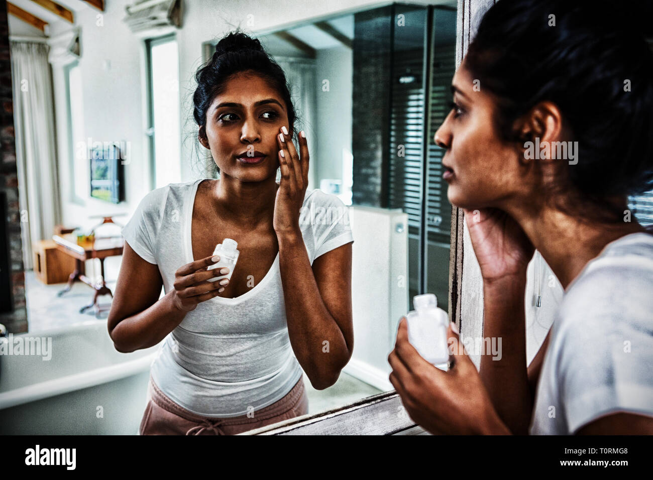 Young woman applying lotion Stock Photo - Alamy