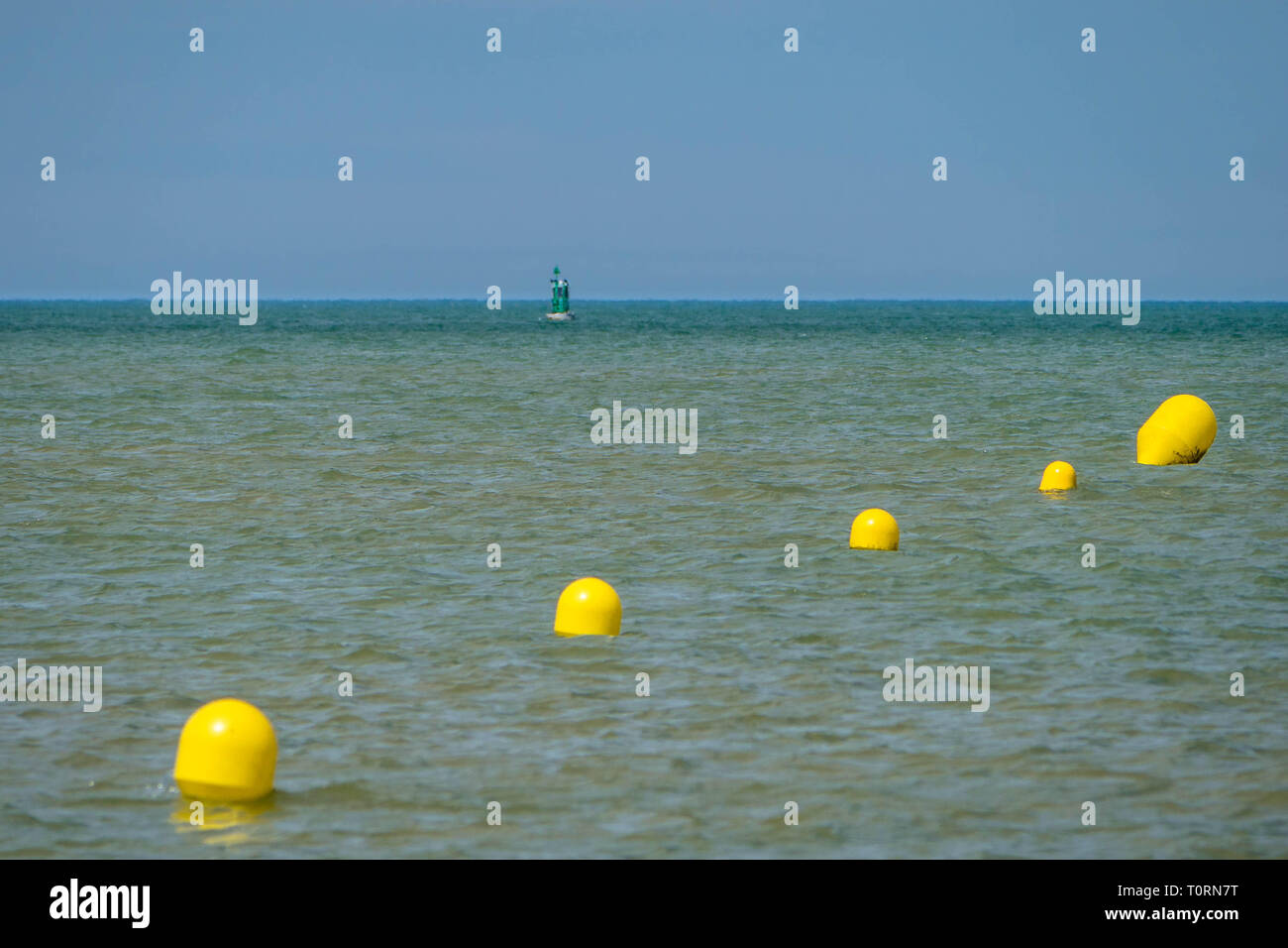 Yellow buoys and mini lighthouse not far from the beach in the sea ...