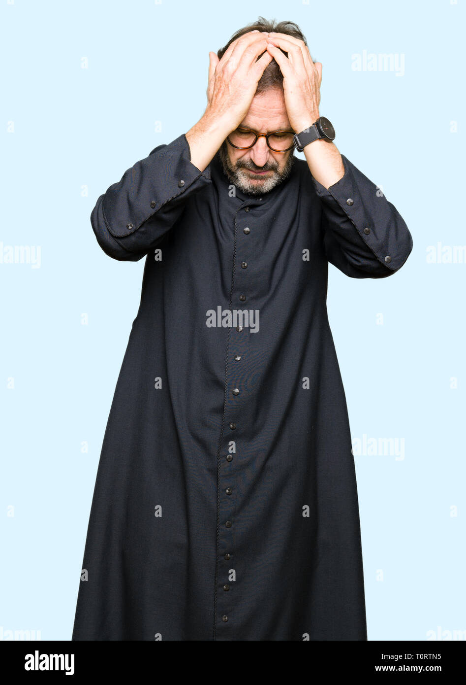 Middle age priest man wearing catholic robe suffering from headache ...