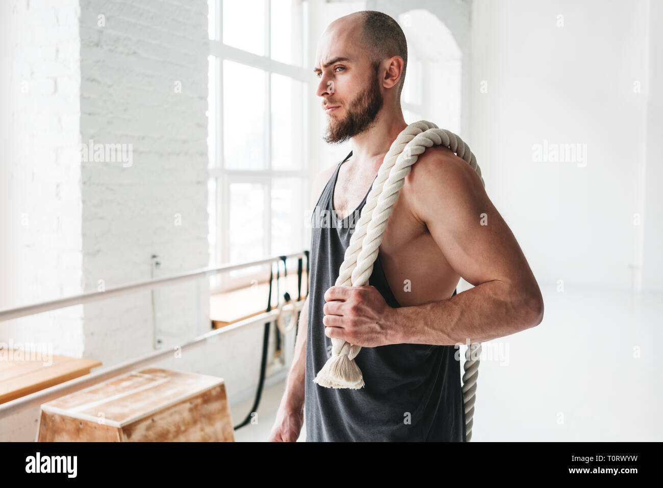 Close up view on fit sportsman with ropes in gym. Muscular athlete ...