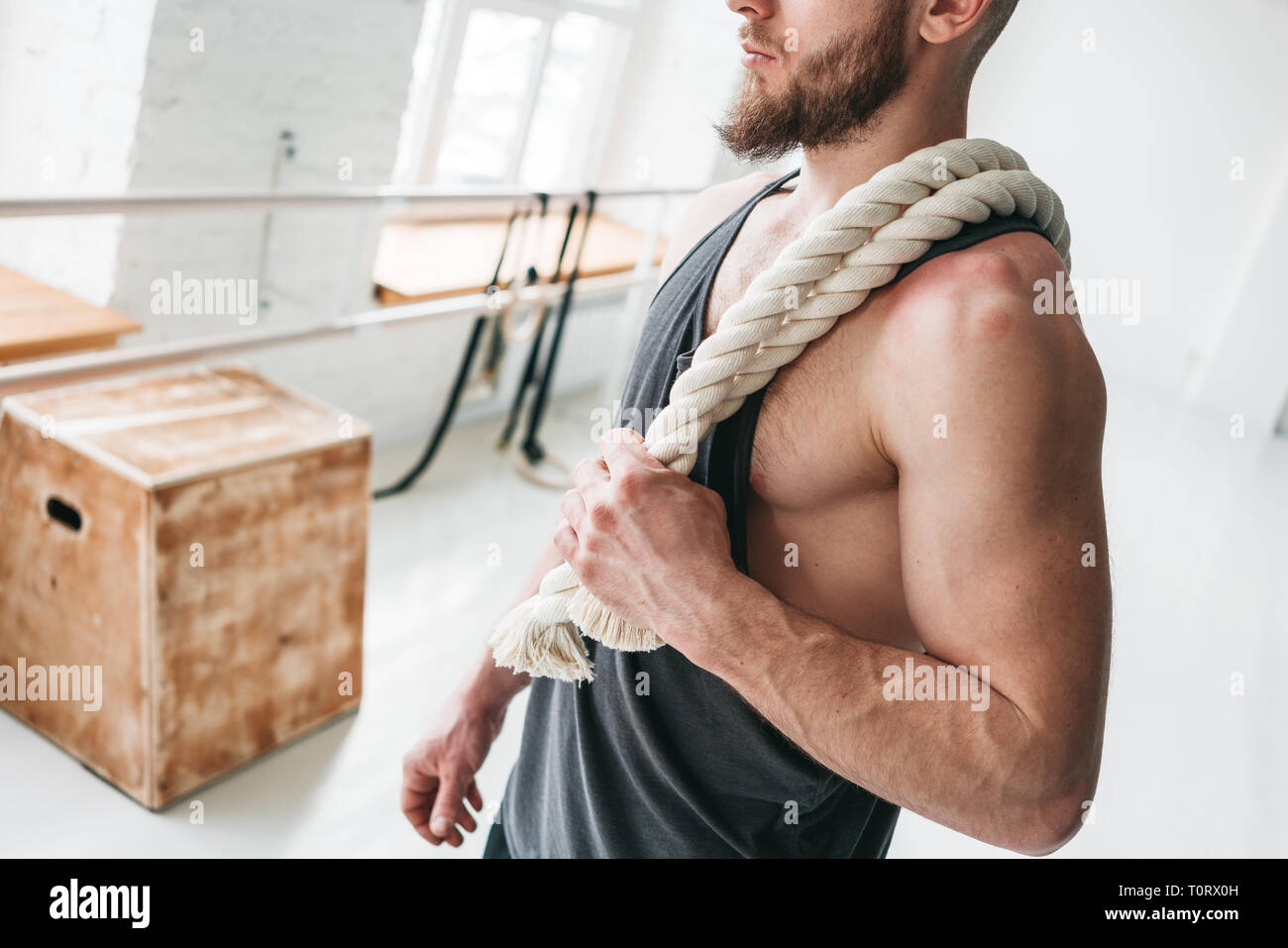 Strong male athlete holding on shoulder rope after intense workout ...
