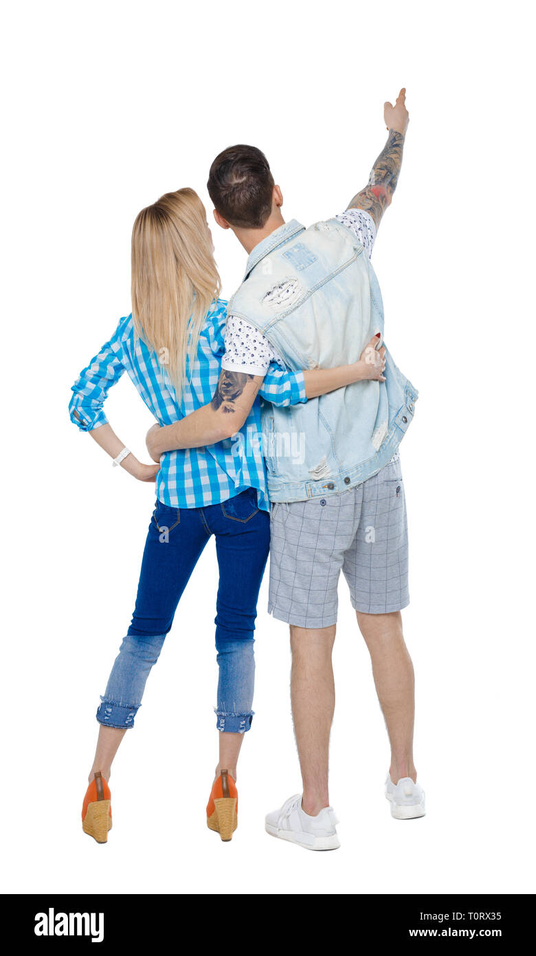 Back view of a heterosexual couple who hugs and points out. Rear view ...