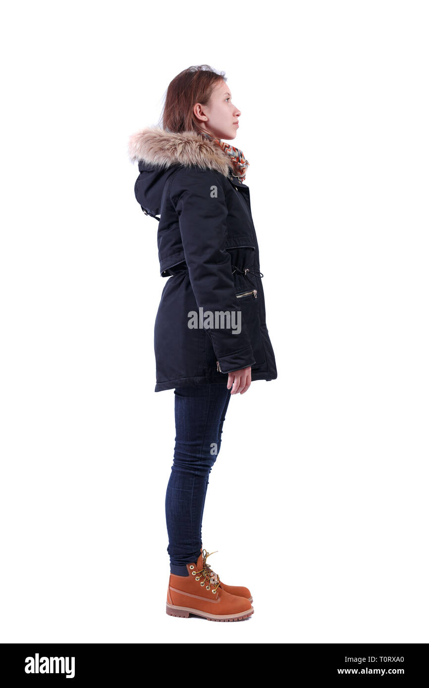 Side view woman in a black winter jacket with fur. Standing young girl ...