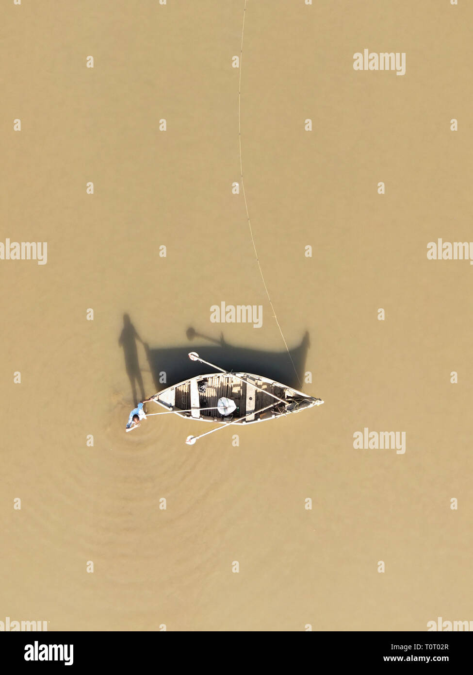 Aerial view of a fisherman with his boat in between the river. Shadow ...
