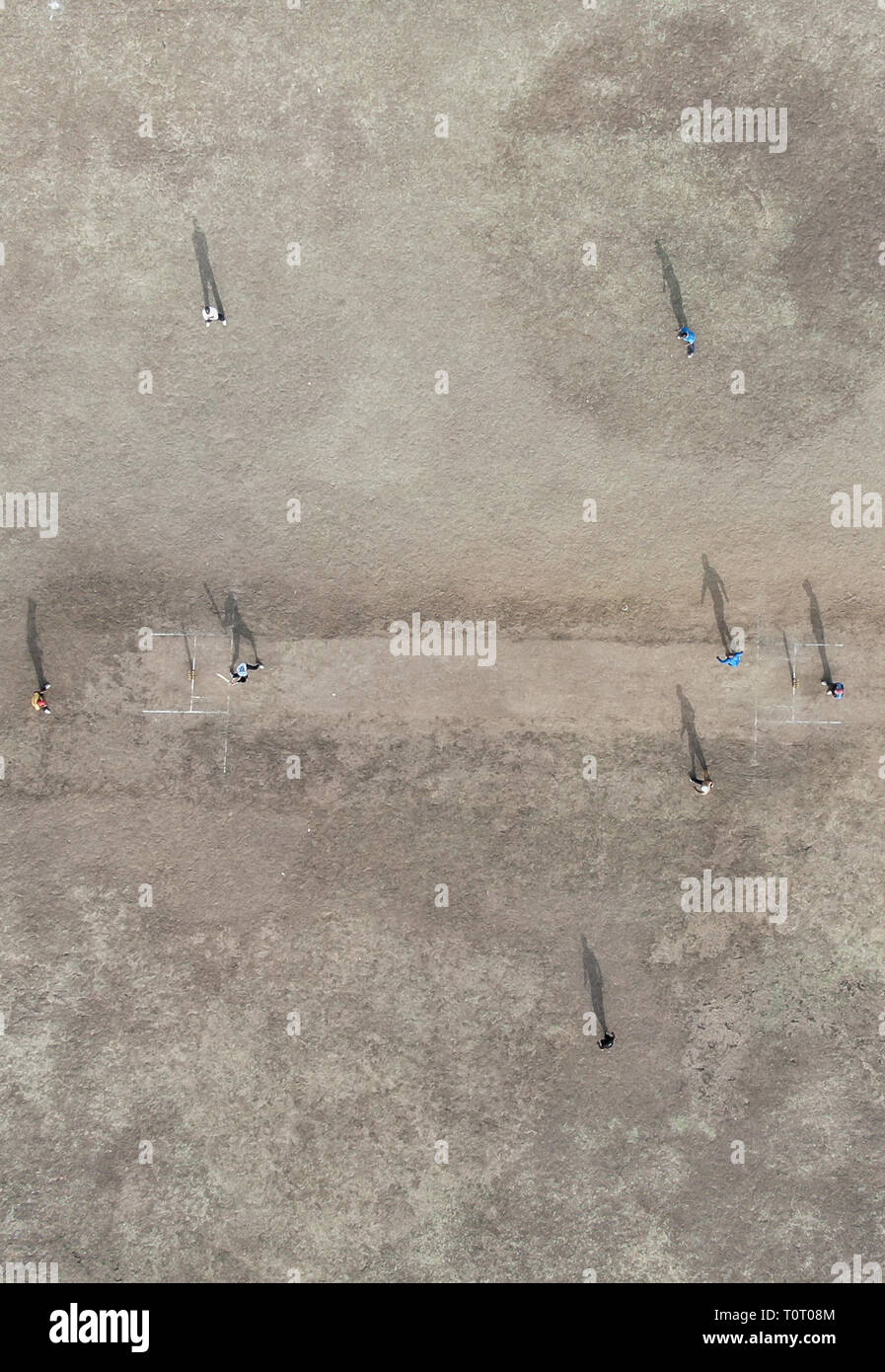 Aerial view of players playing cricket. Shadow play of crickets playing ...