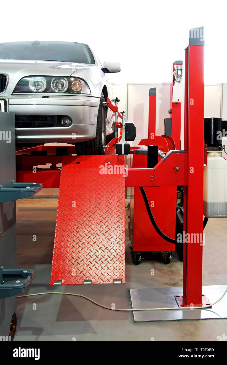 Auto service garage with car at lift Stock Photo - Alamy