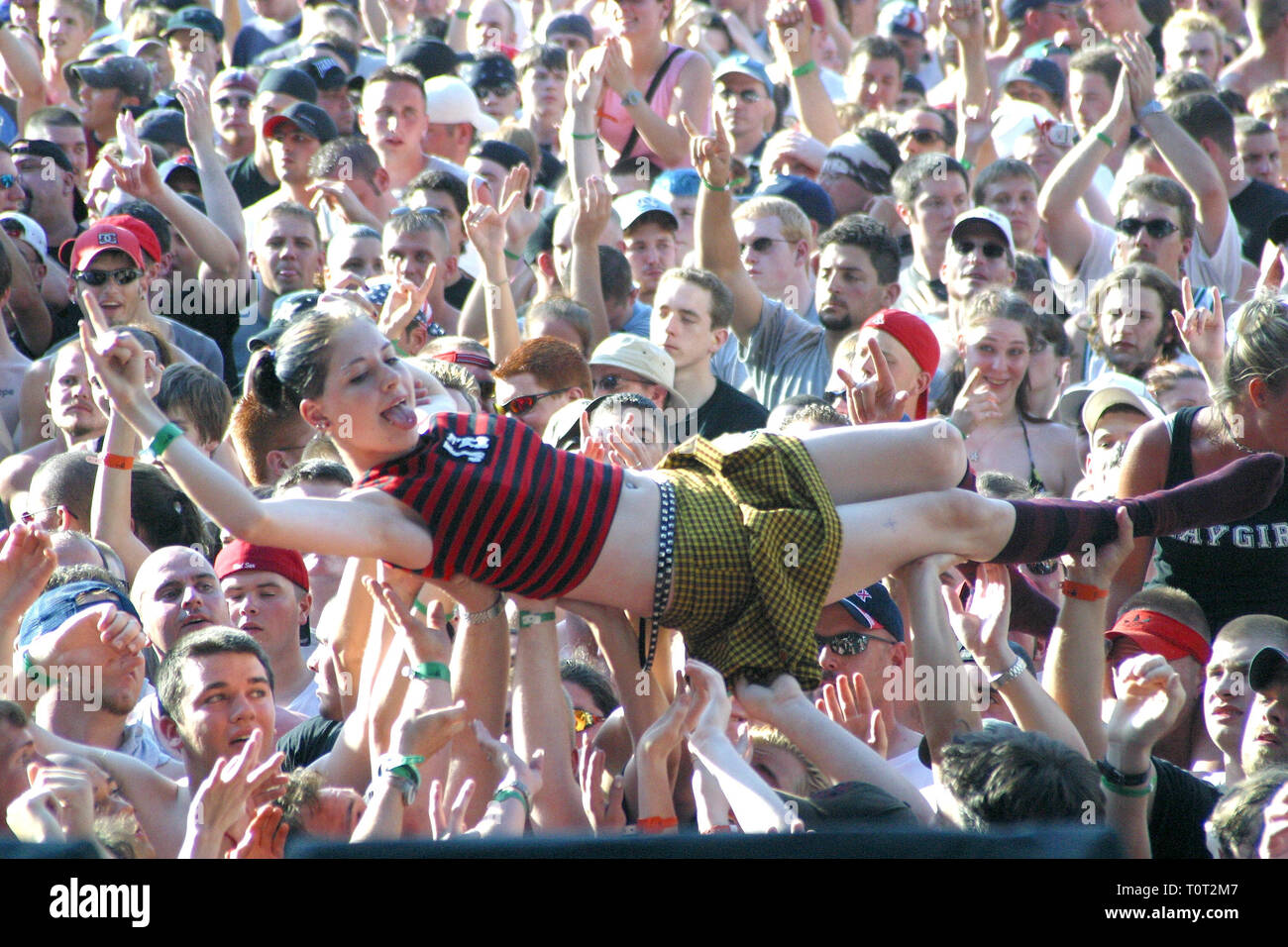 A female concert fan is shown body surfing across the top of the crowd ...