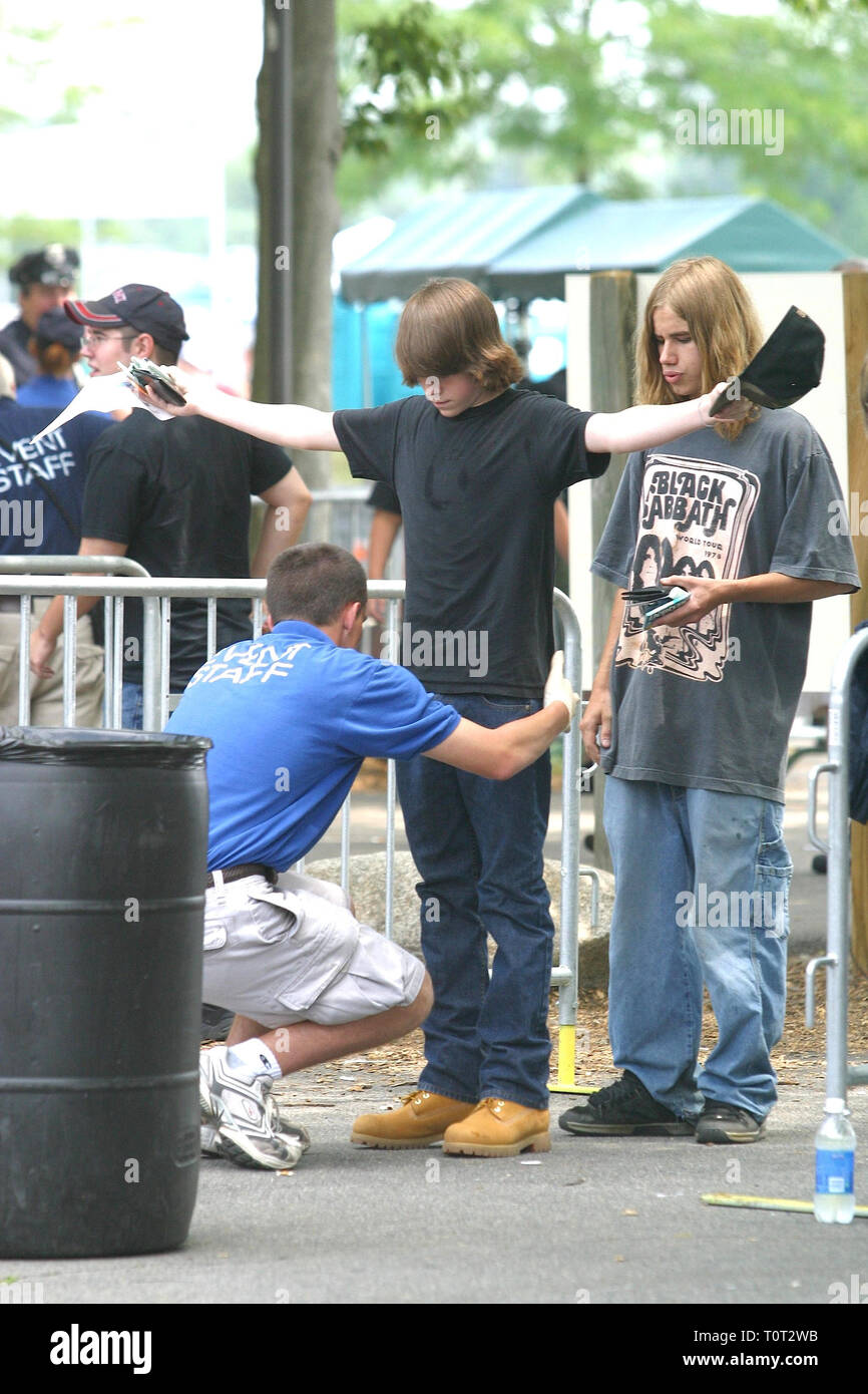 A concert fan is being searched by security at the entrance gate of a ...